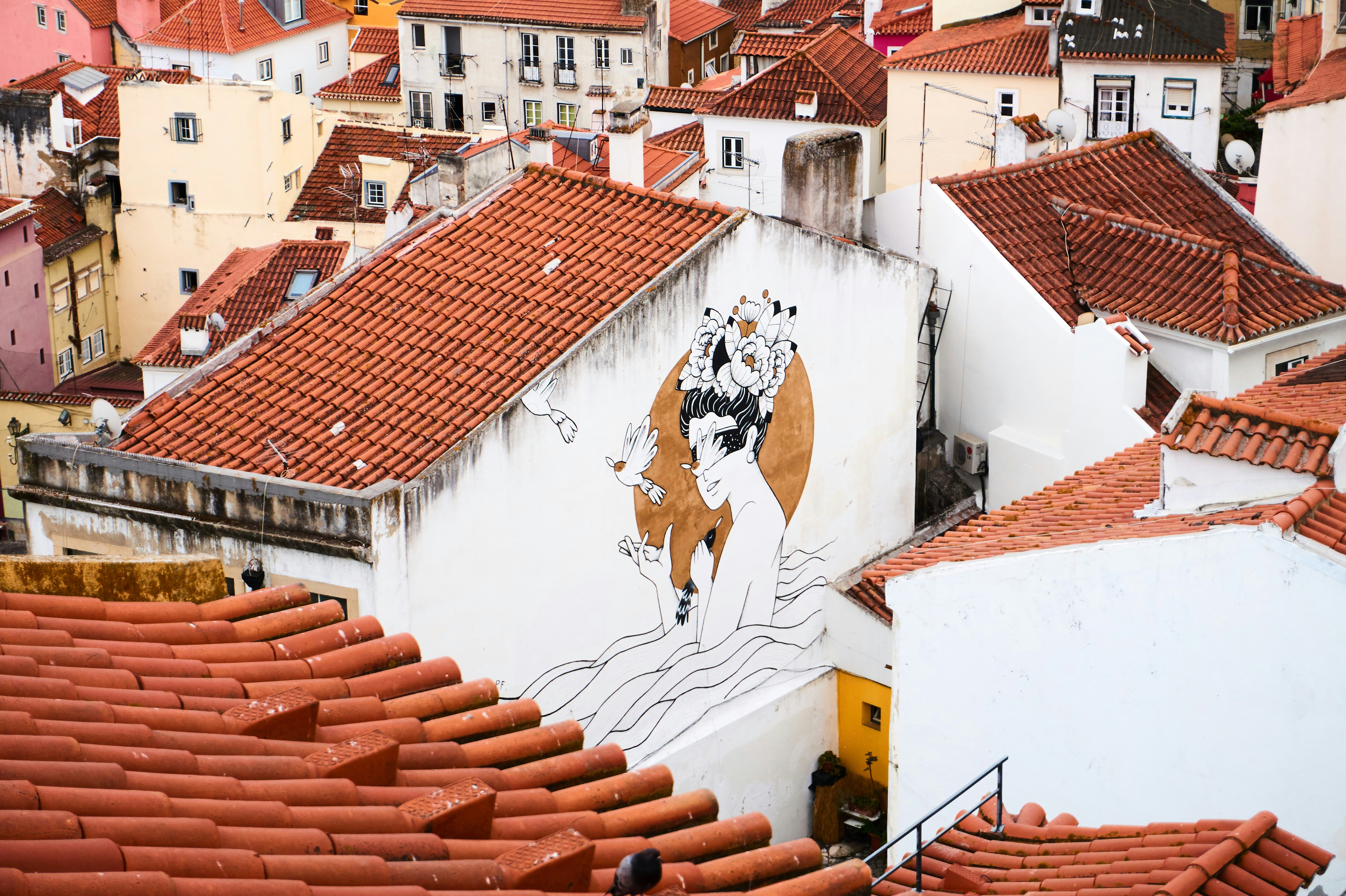 Mural Amid the Rooftop Sea: A Stylized Figure on a White Wall