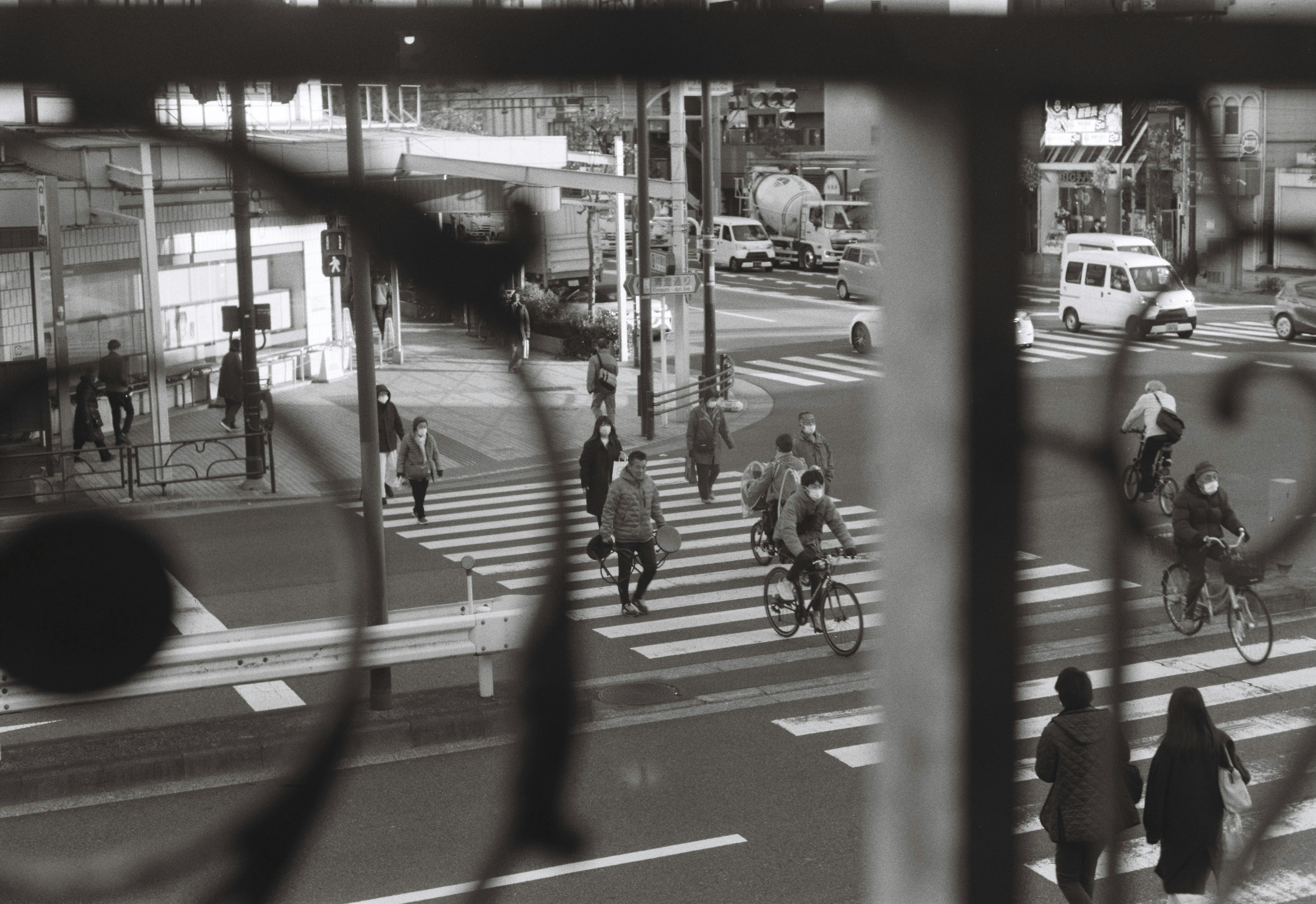 Monochrome Crosswalk: A City's Quiet Ballet of Pedestrians and Cyclists