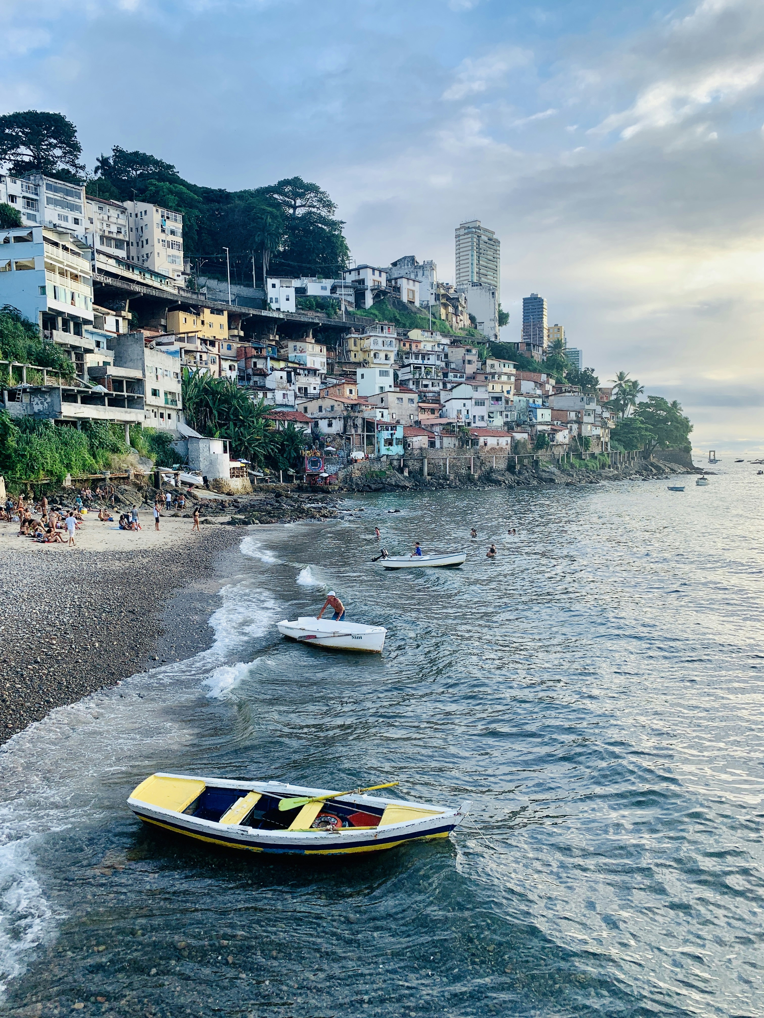 Colorful hillside village by the sea with boats at dusk