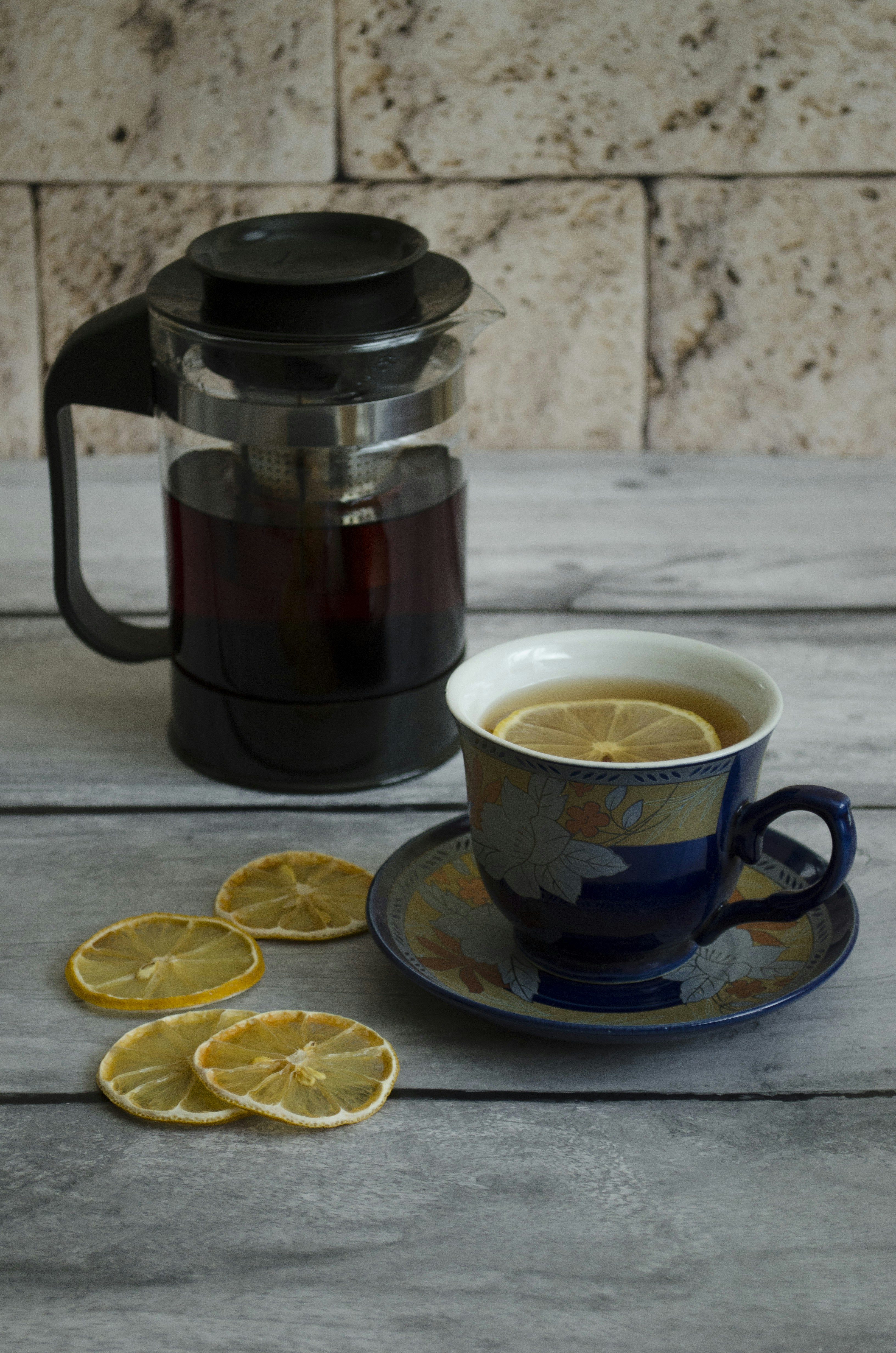 A cup of tea with lemon slices next to it photo – Free Drink Image on ...