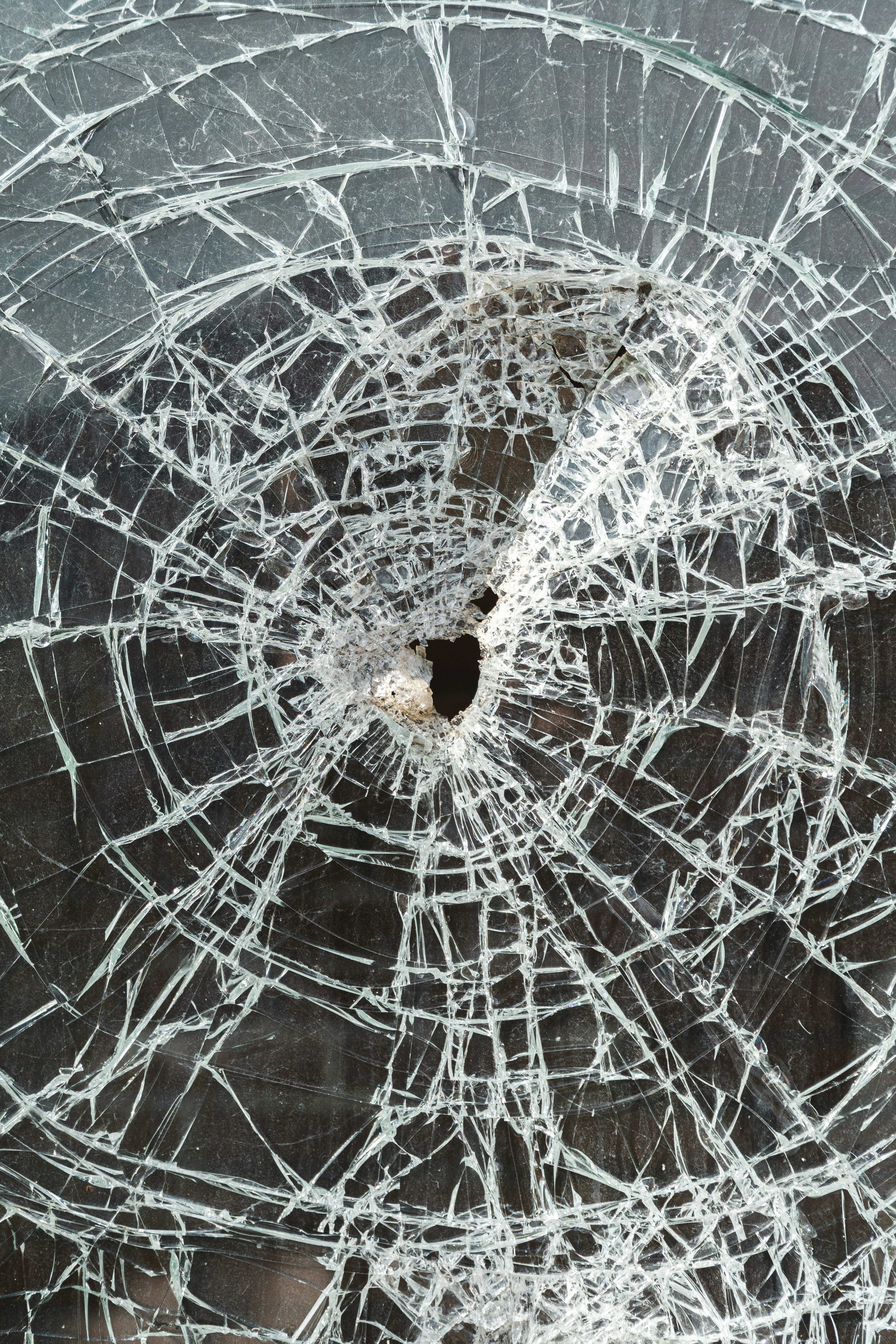 A cracked glass window with a hole in it photo – Free Grey Image on ...