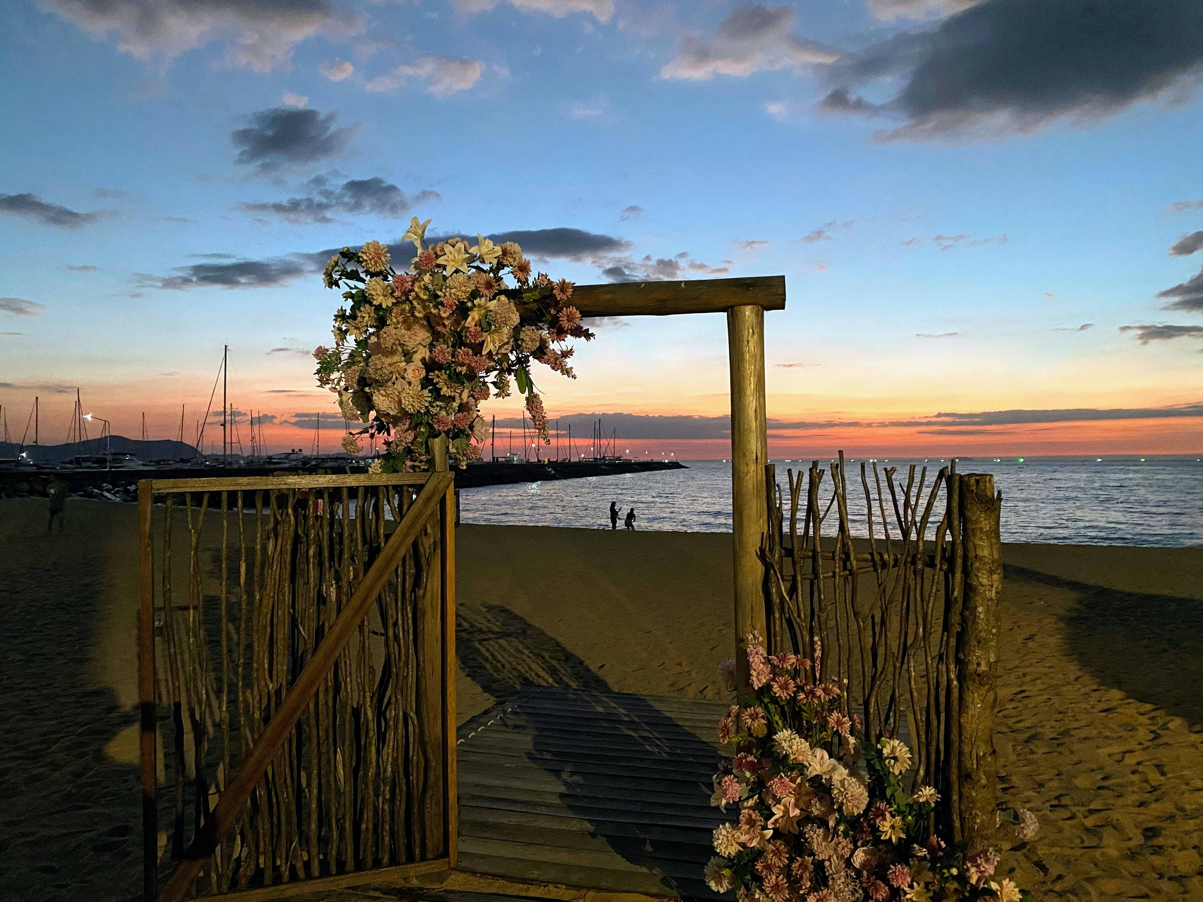 A wooden gate on a beach with flowers on it photo – Free Flower Image ...