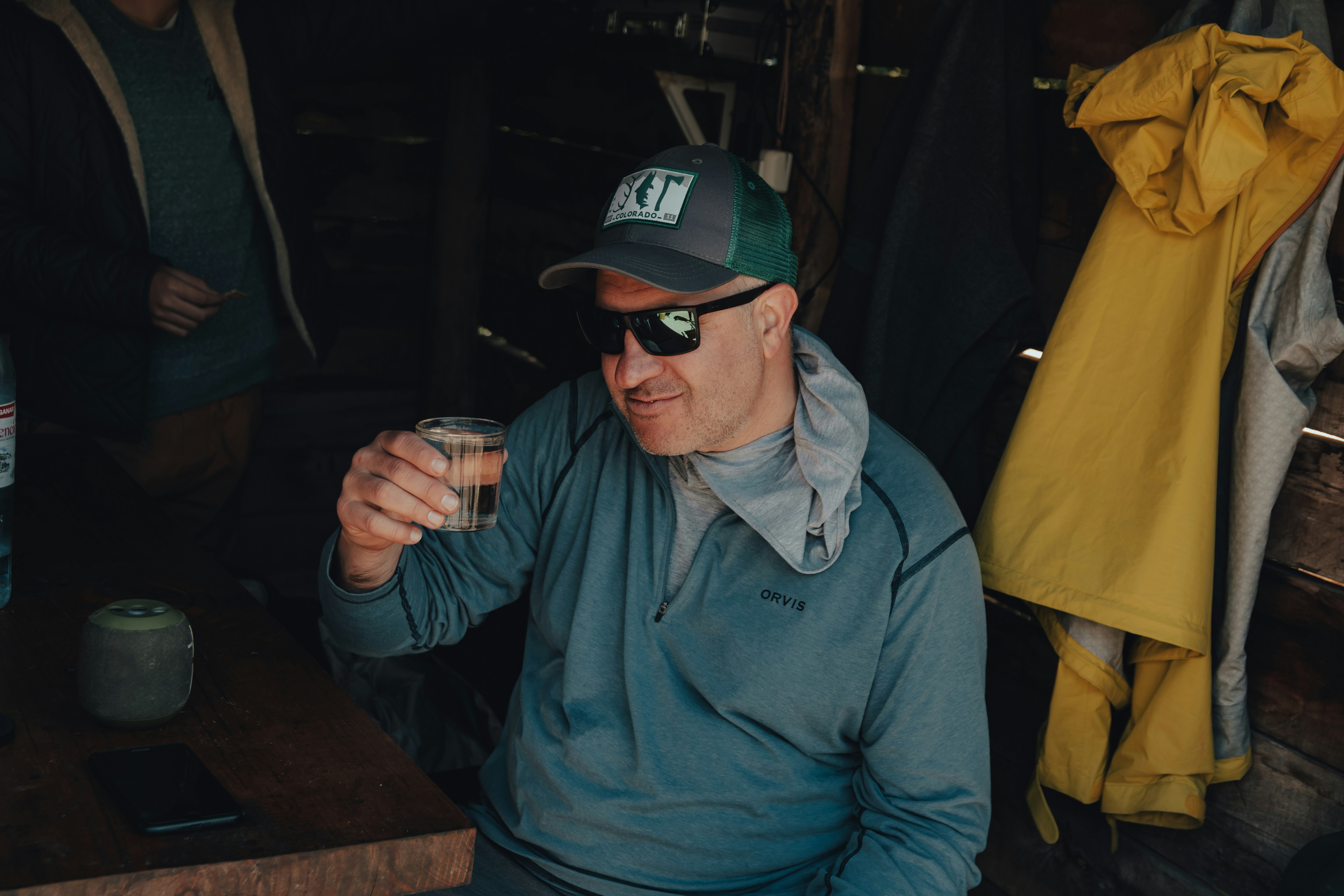 Quiet Respite in a Dim Shed: A Man Sips in Warm Light