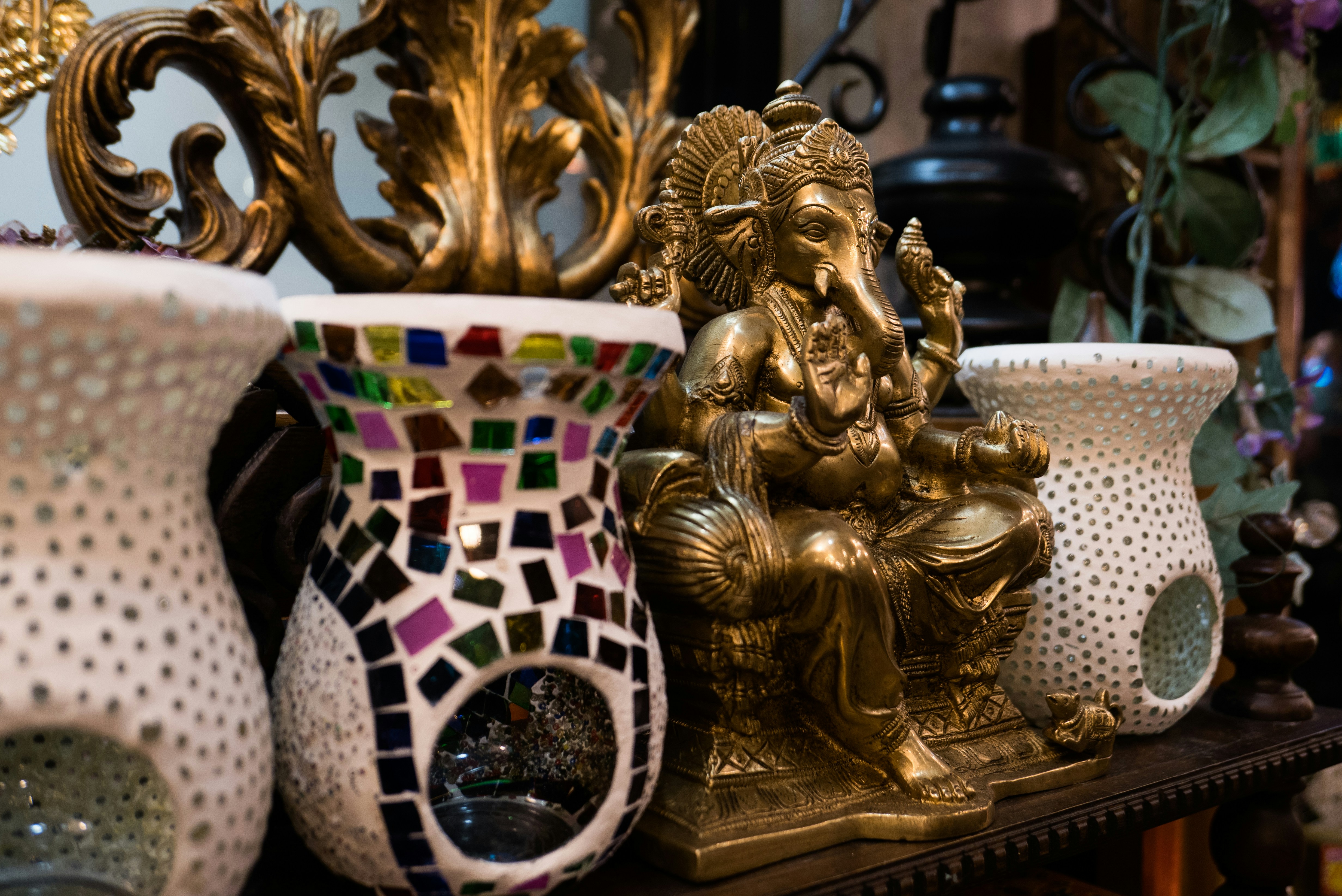 Bronze Ganesha Between Mosaic Vessels on a Quiet Shelf