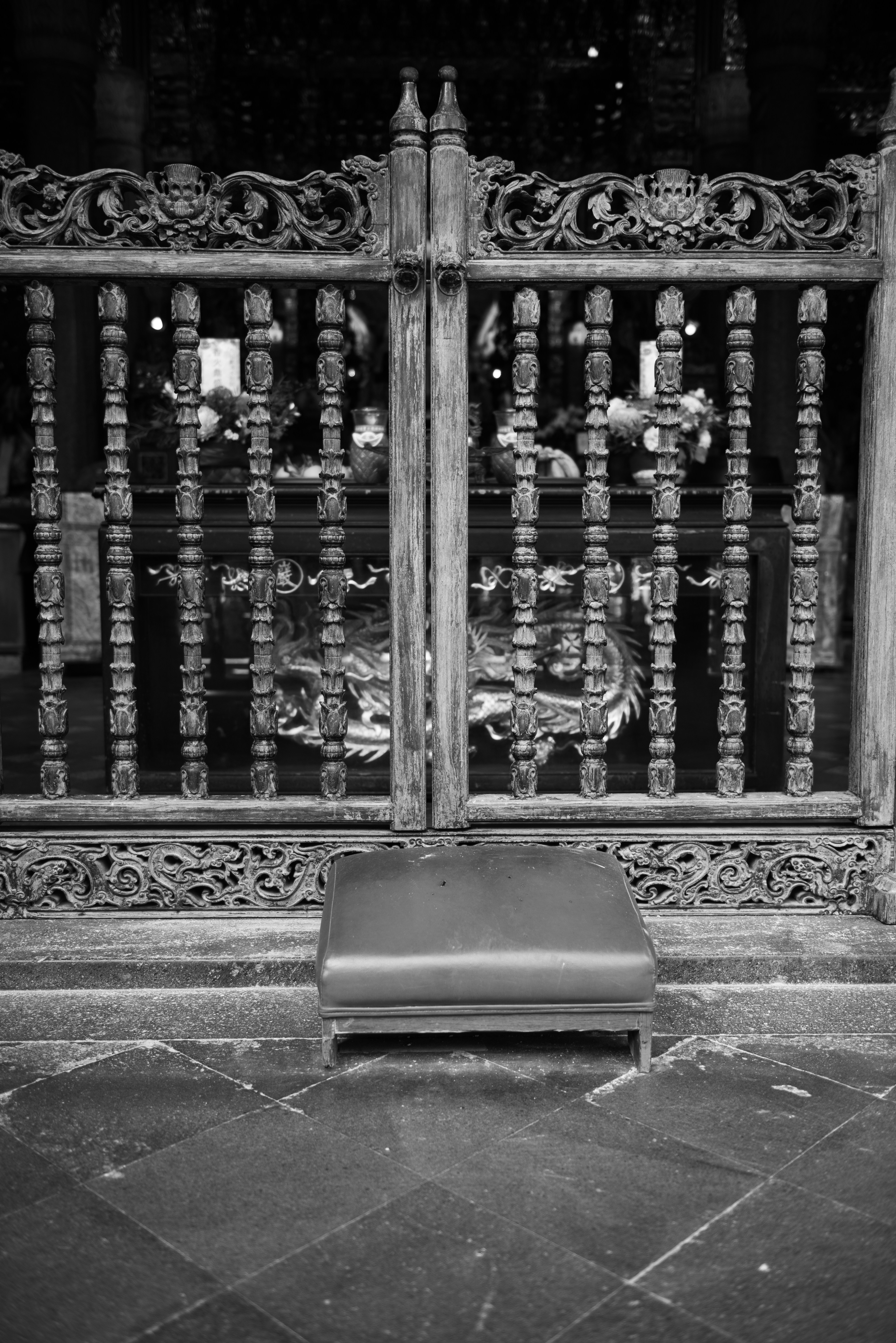 Empty Bench Before Ornate Gate: A Stilled Moment in Black and White