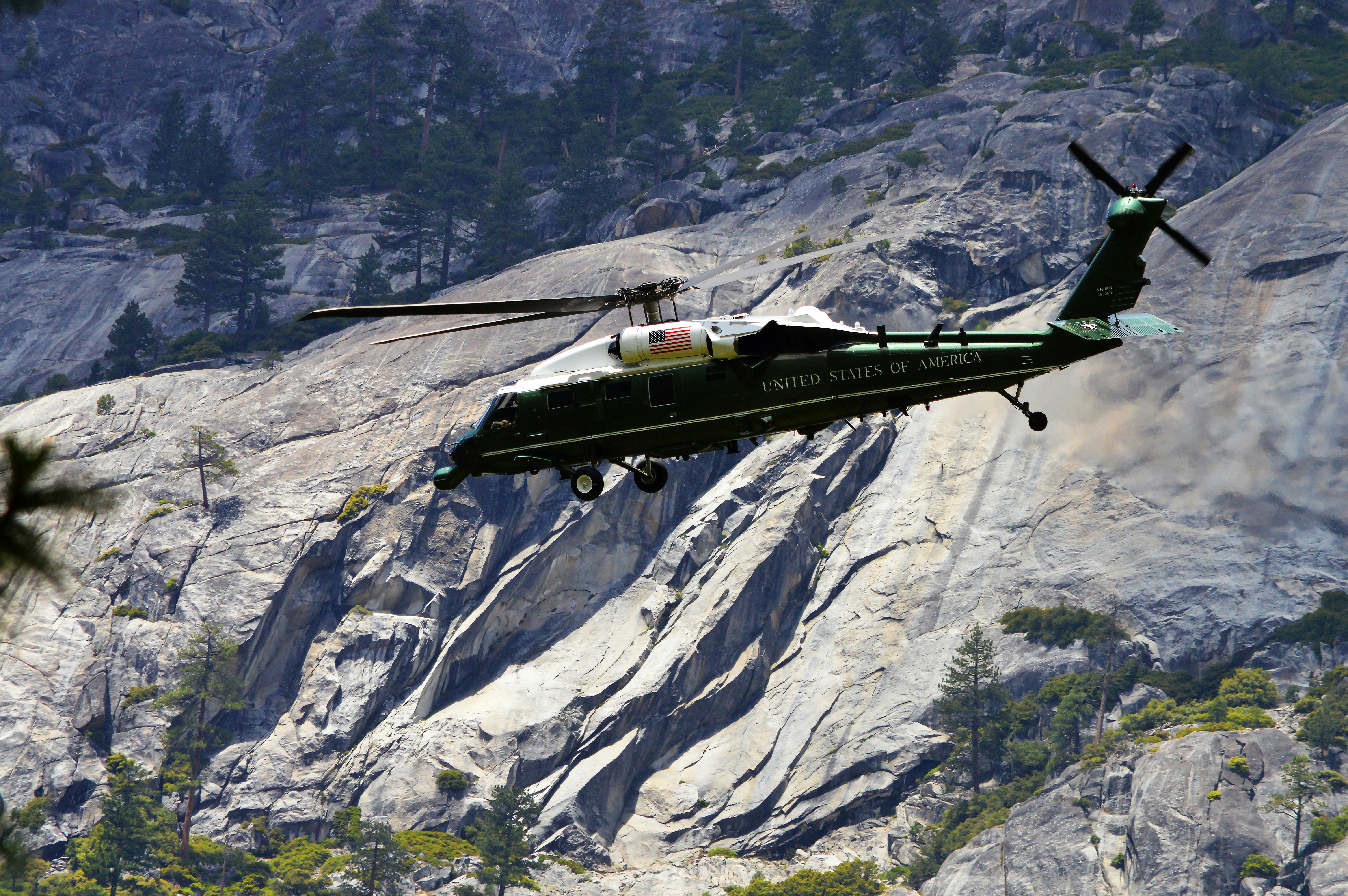 A helicopter is flying over a mountain side photo – Free Yosemite ...