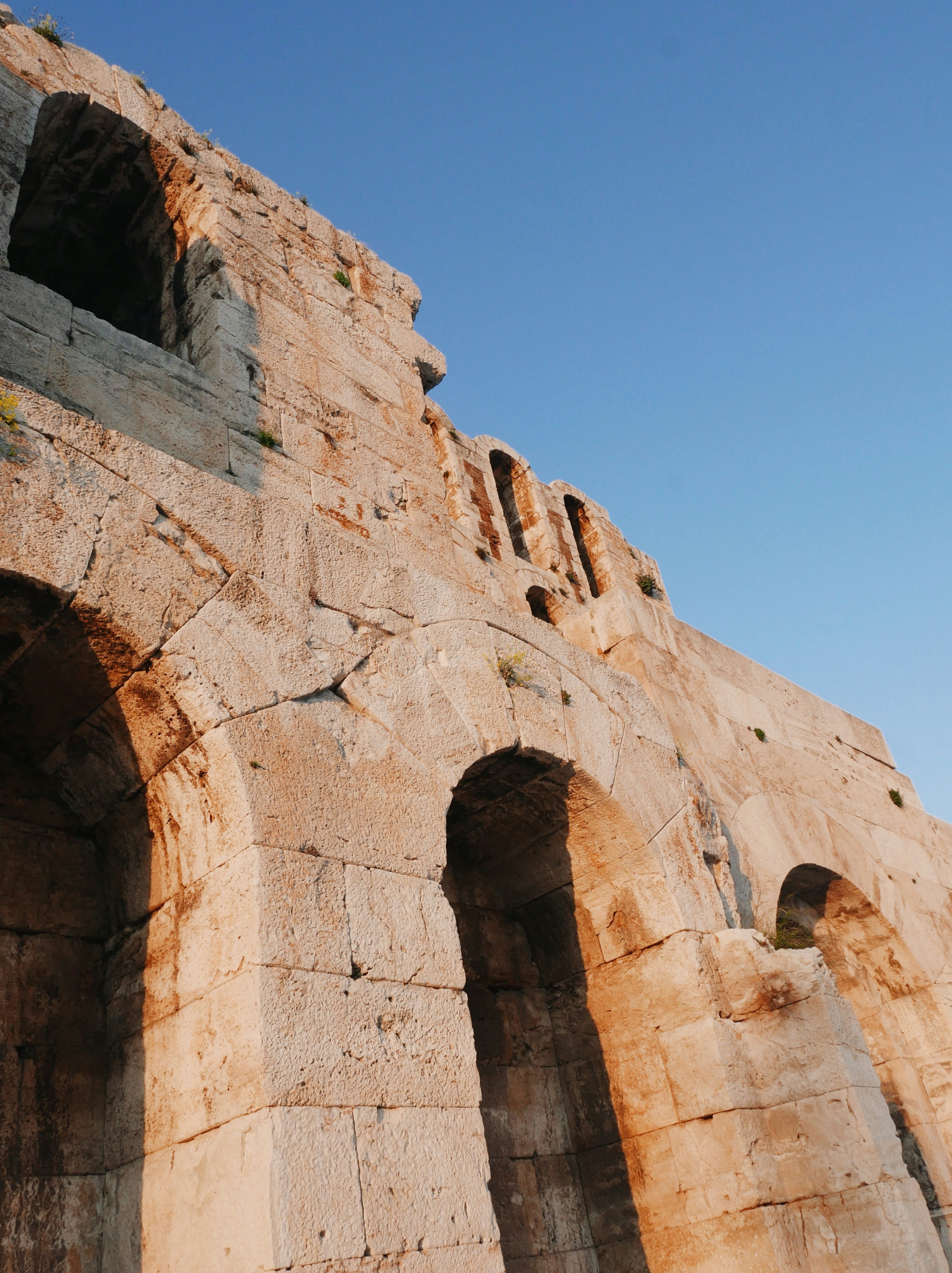 A large stone building with three windows and a sky background photo ...
