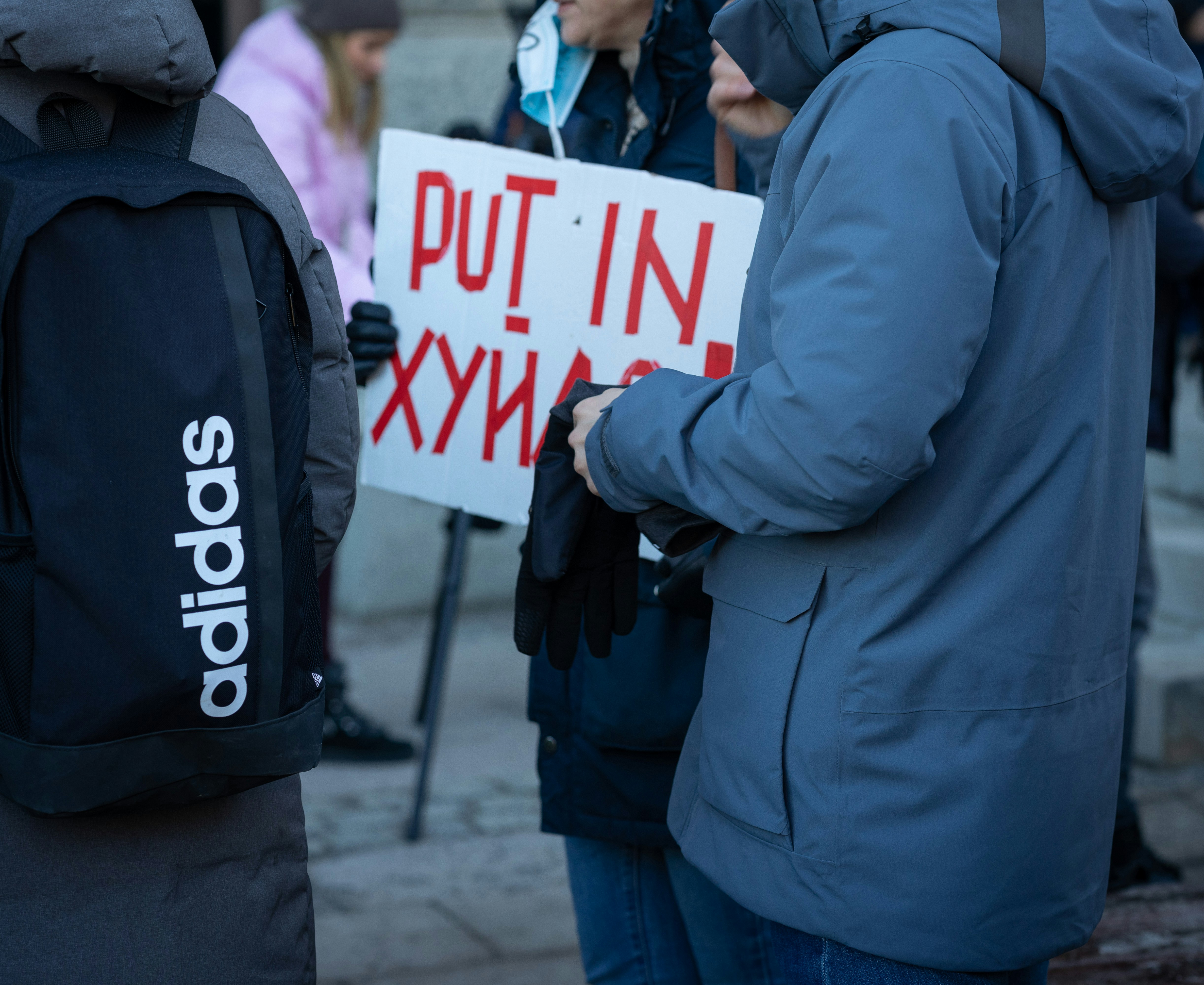 A group of people standing around holding signs photo – Free ...