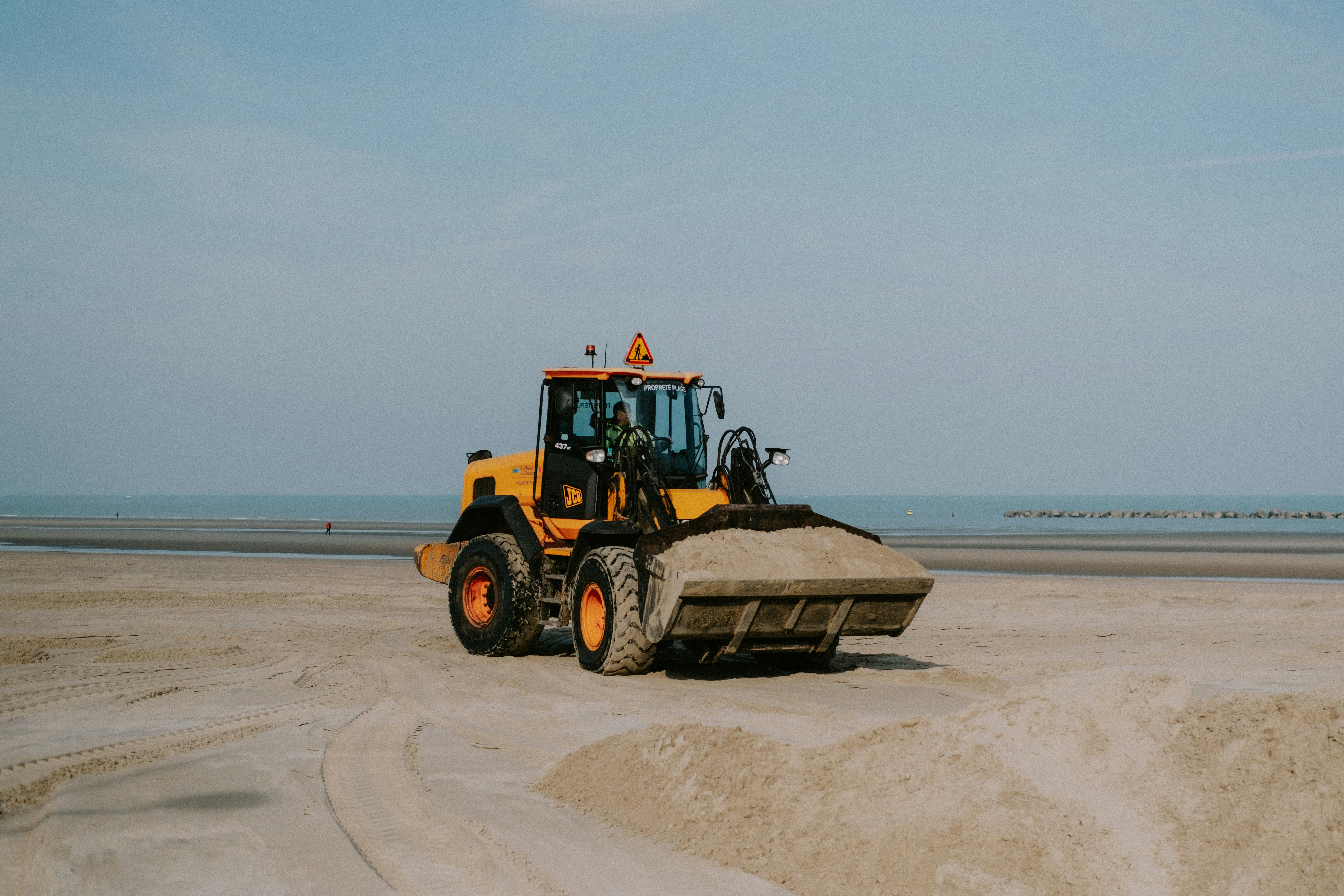 Coastal Scraper: A Frontier Loader on Sunlit Sand