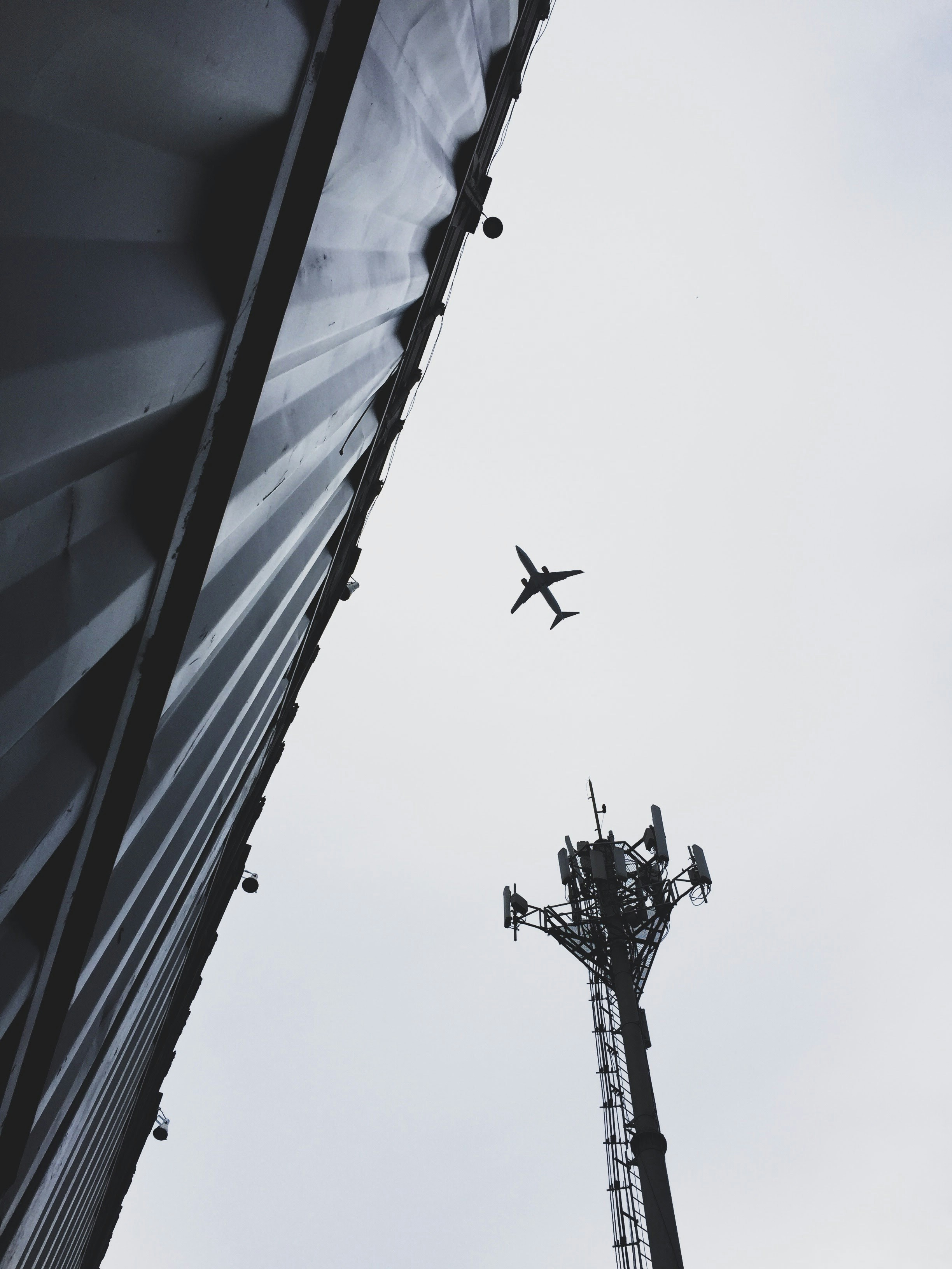 Foto Un avión está volando sobre una estructura alta – Imagen Avión ...