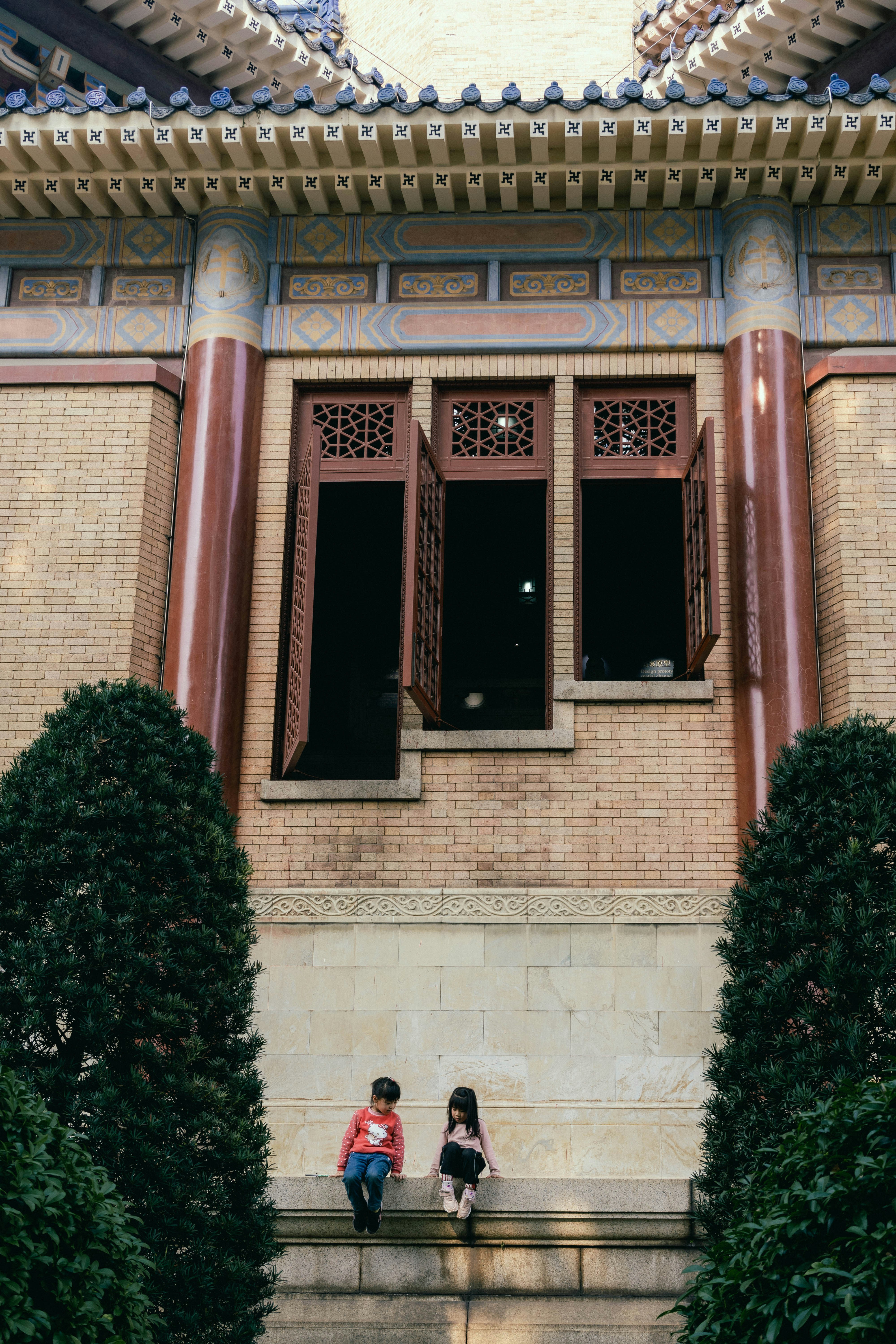 a couple of people sitting on top of a stone bench