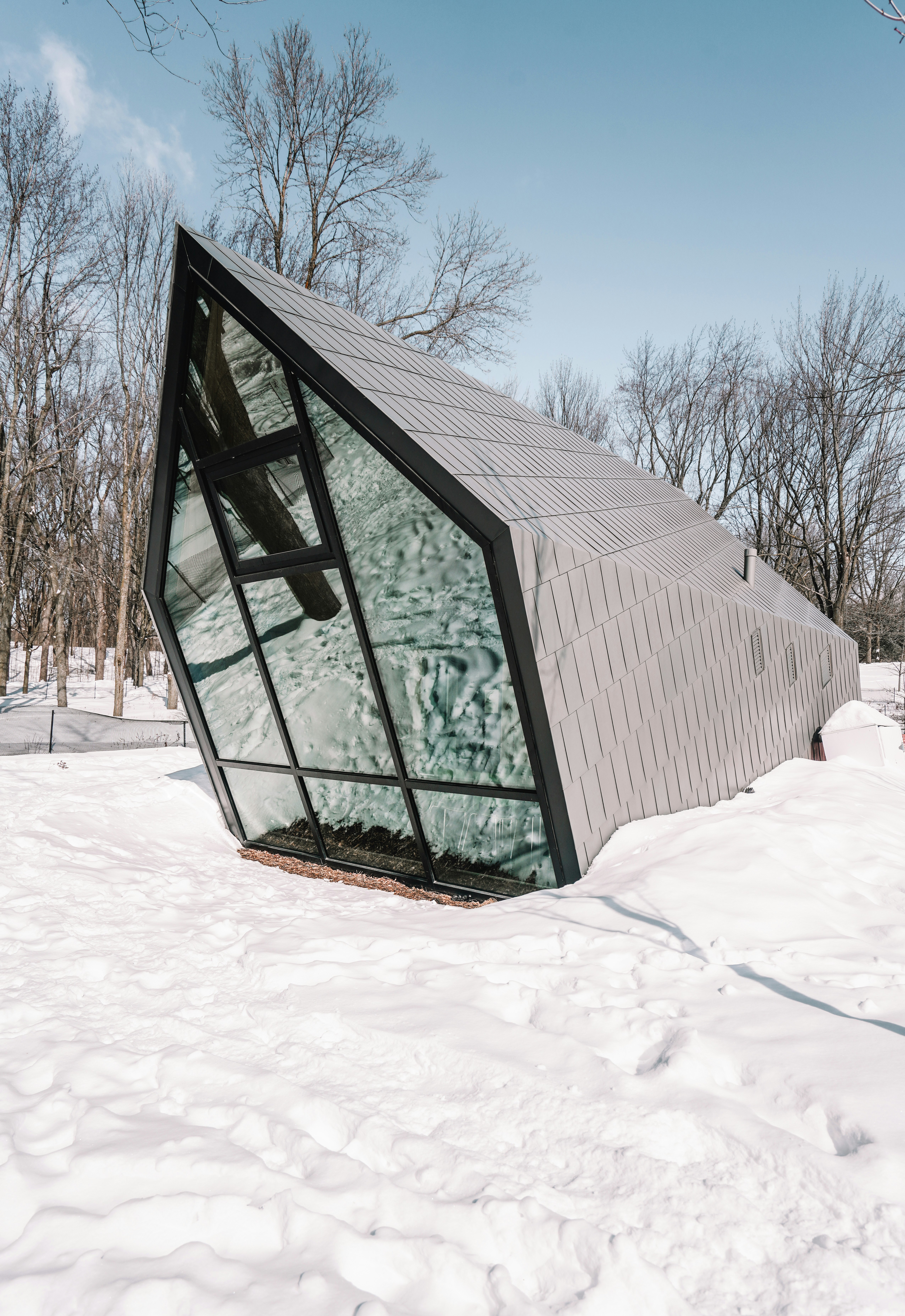A triangular shaped building in the middle of a snow covered field ...