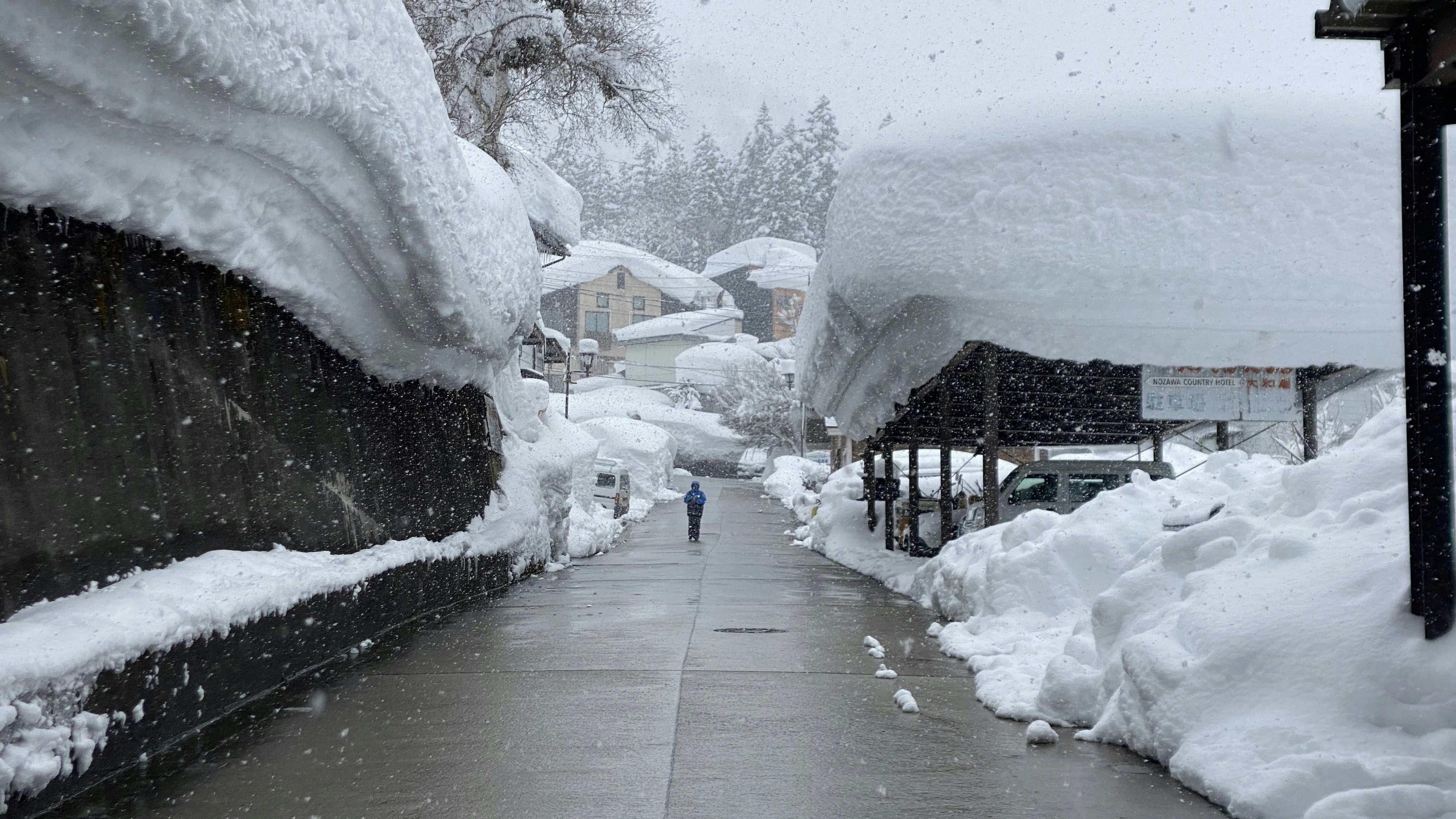 A person walking down a snow covered sidewalk photo – Free Japan Image ...