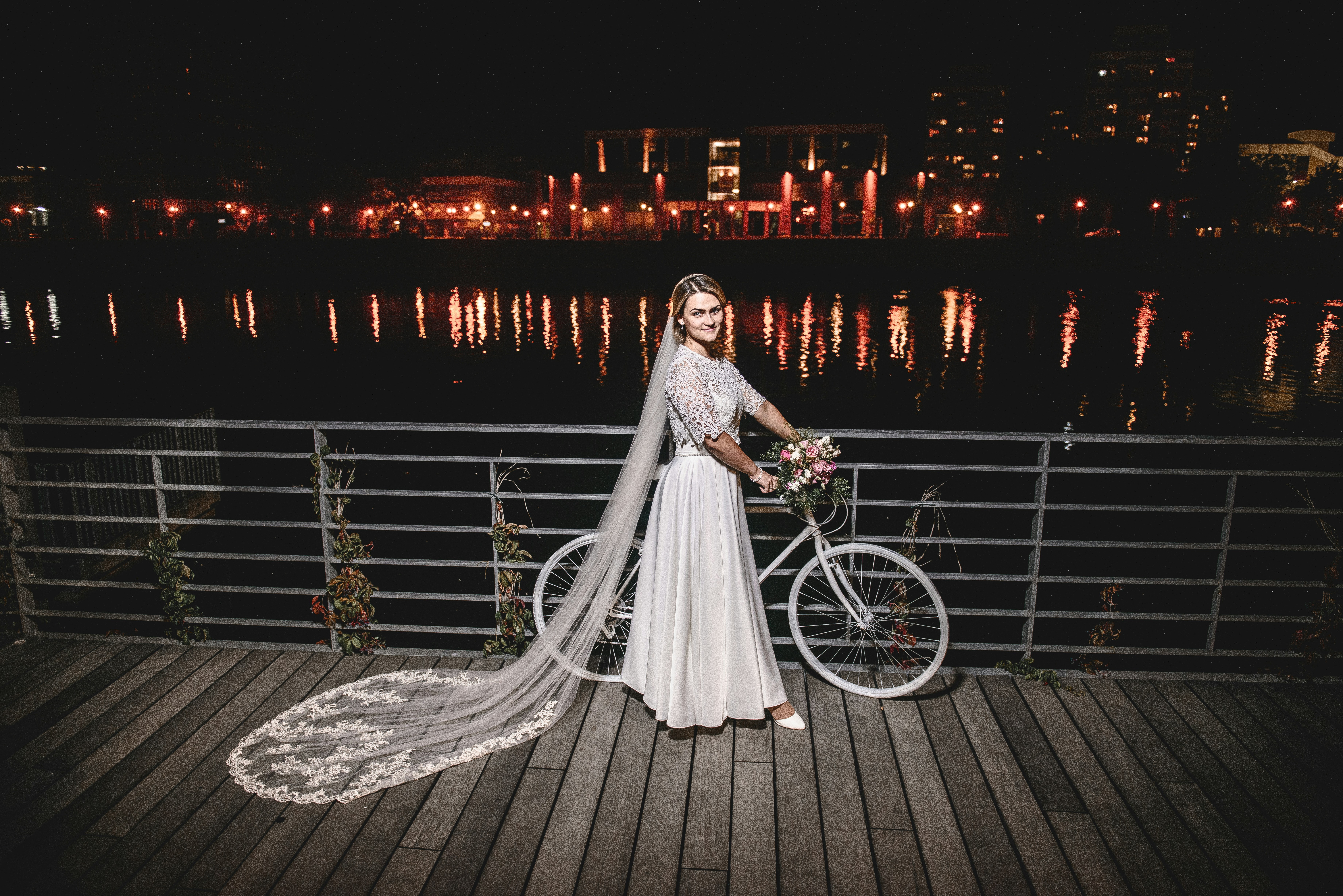 Bride in Long Train with Bicycle Florals by Waterfront Night