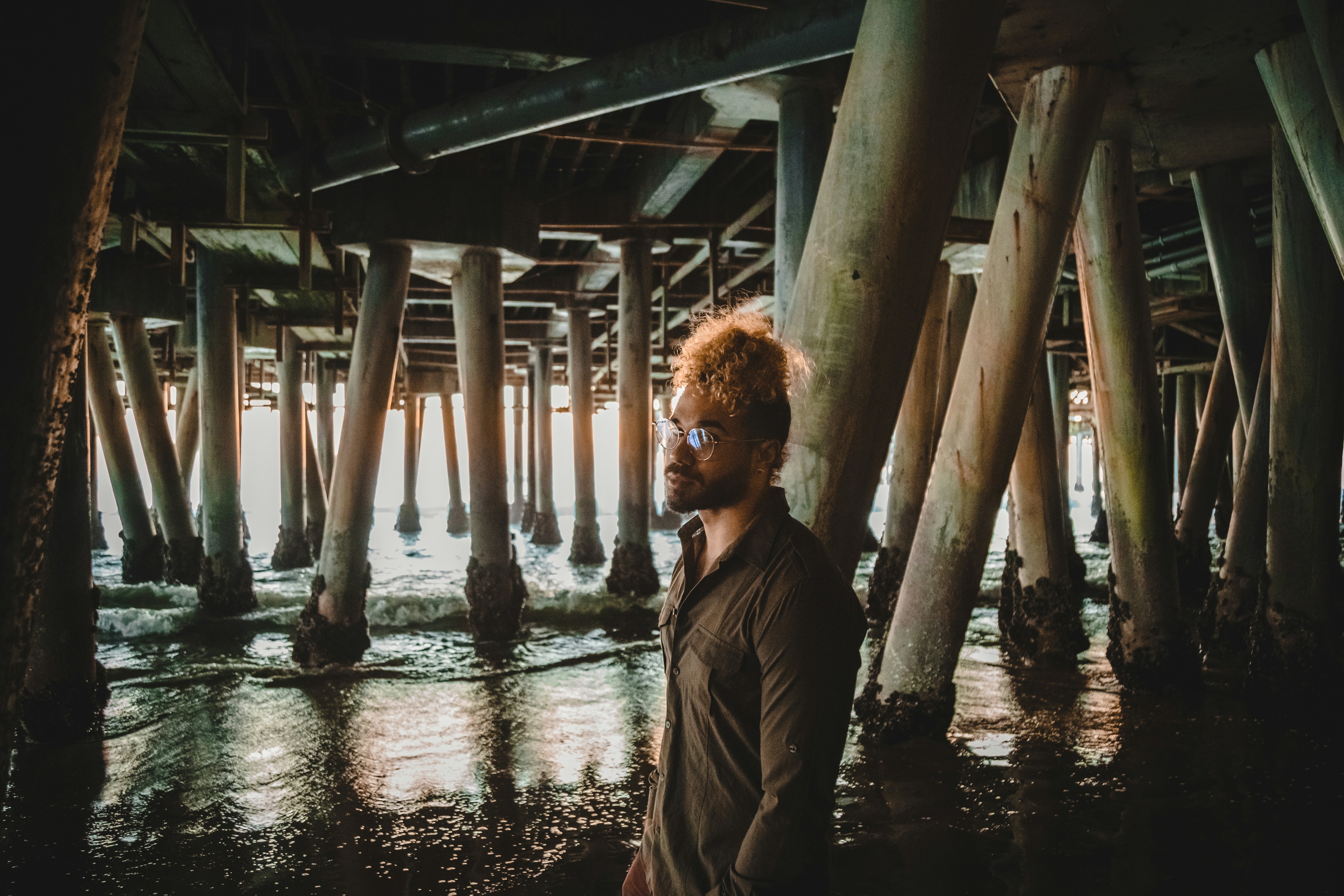 Un homme debout sous une jetée au bord de l’océan photo – Photo Jetée ...