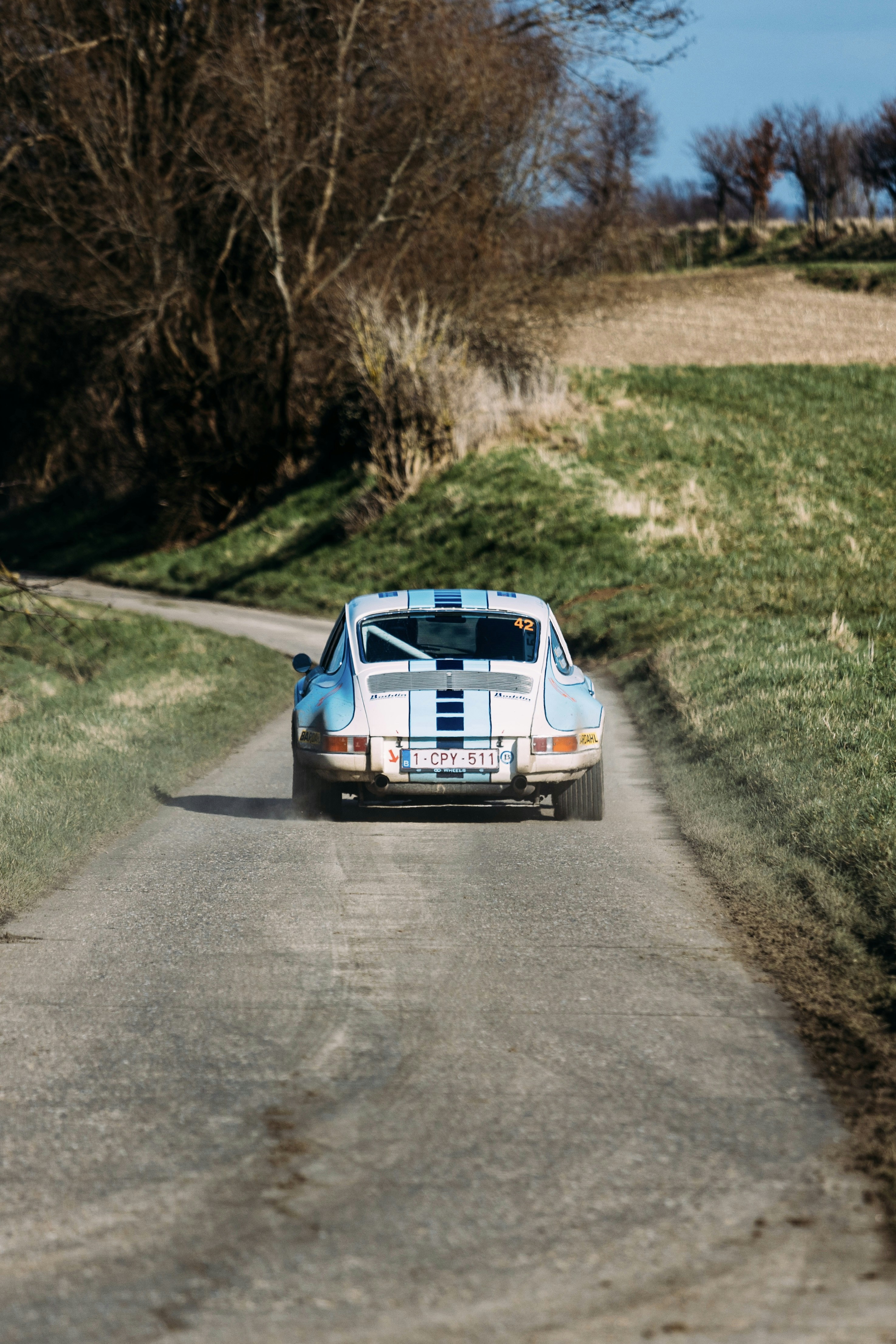 A small car driving down a country road photo – Free Tarmac Image on ...