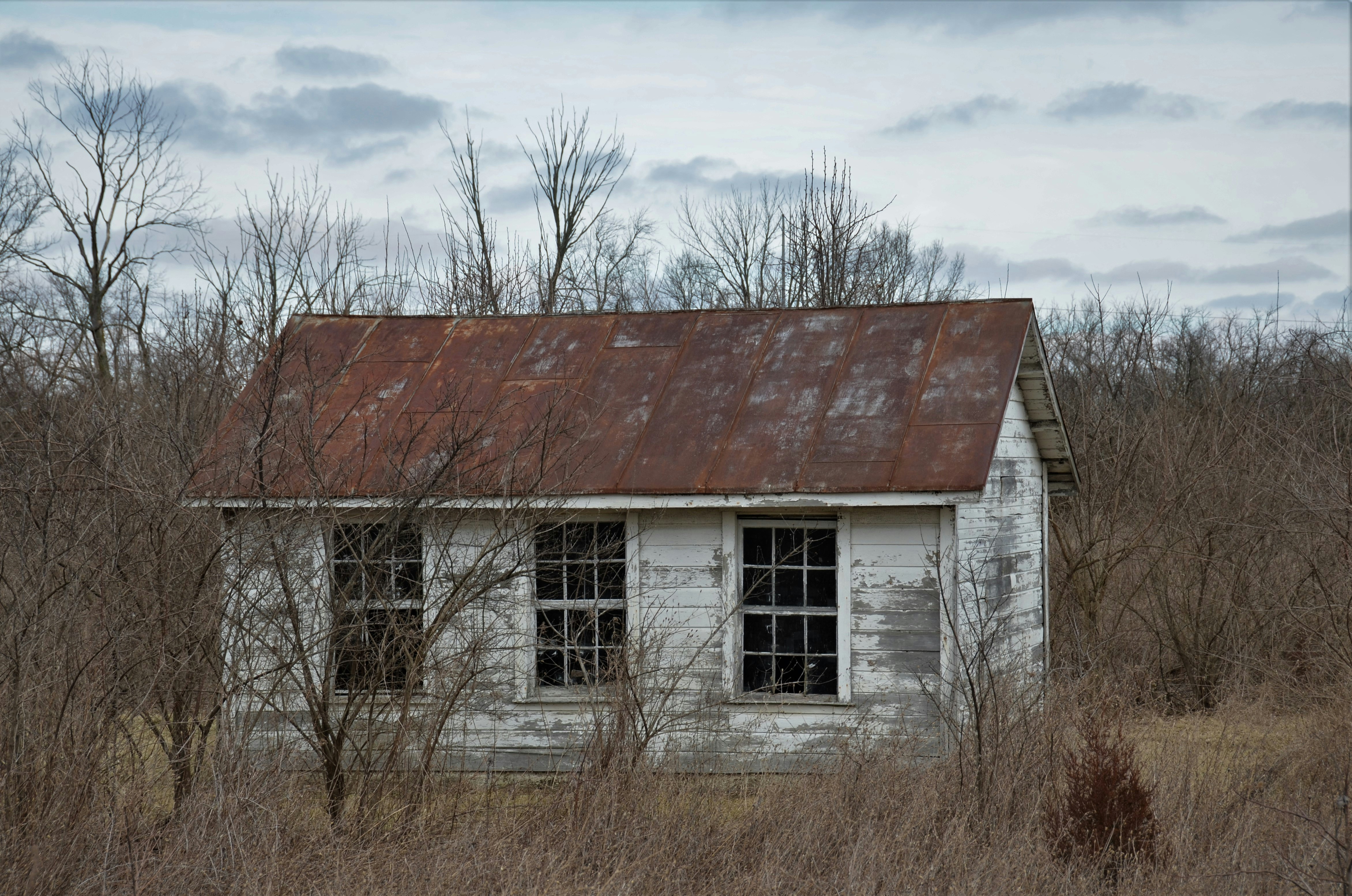 An old run down house in the middle of a field photo – Free Grey Image ...