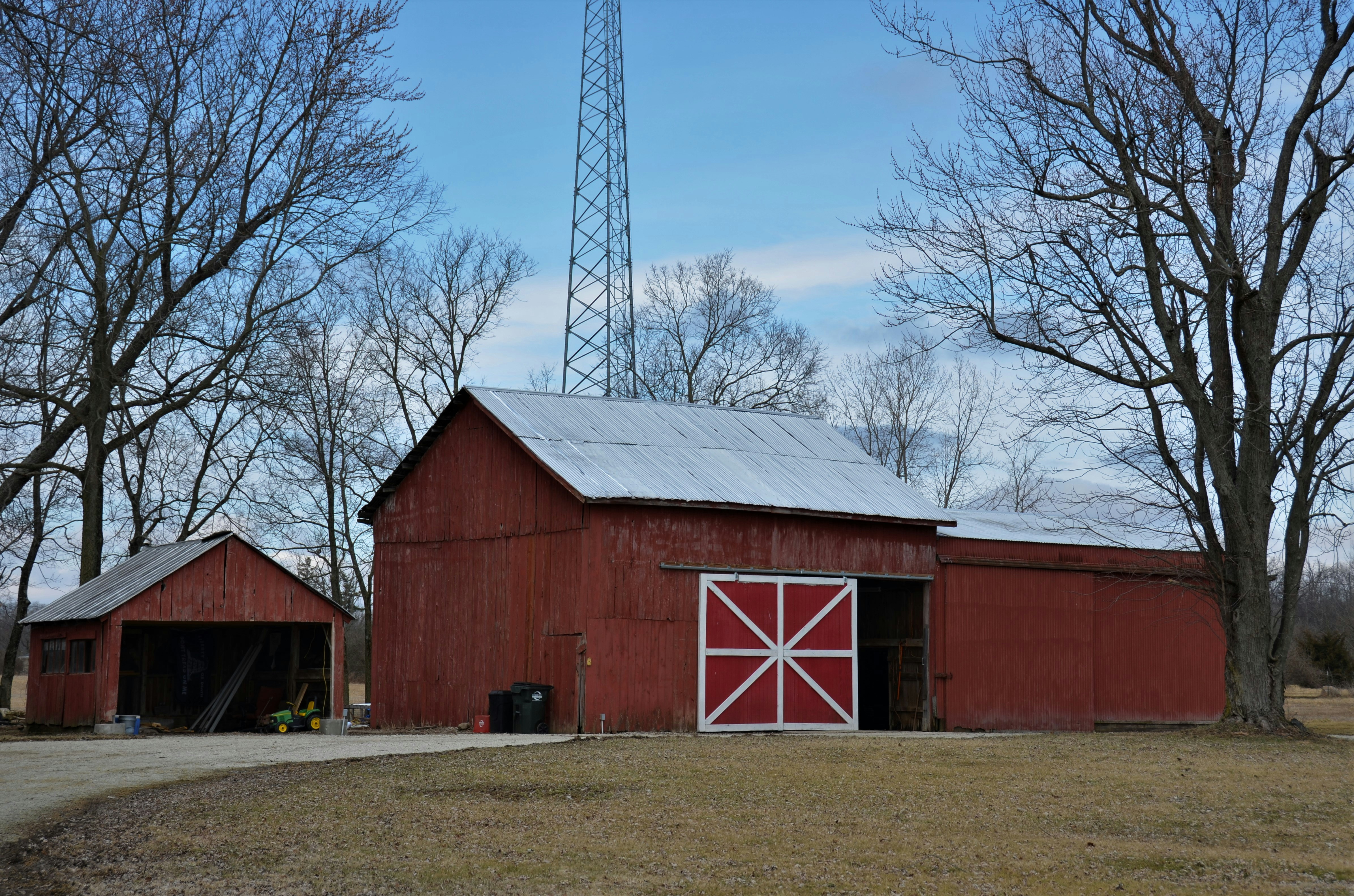 A red barn with a radio tower in the background photo – Free Building ...
