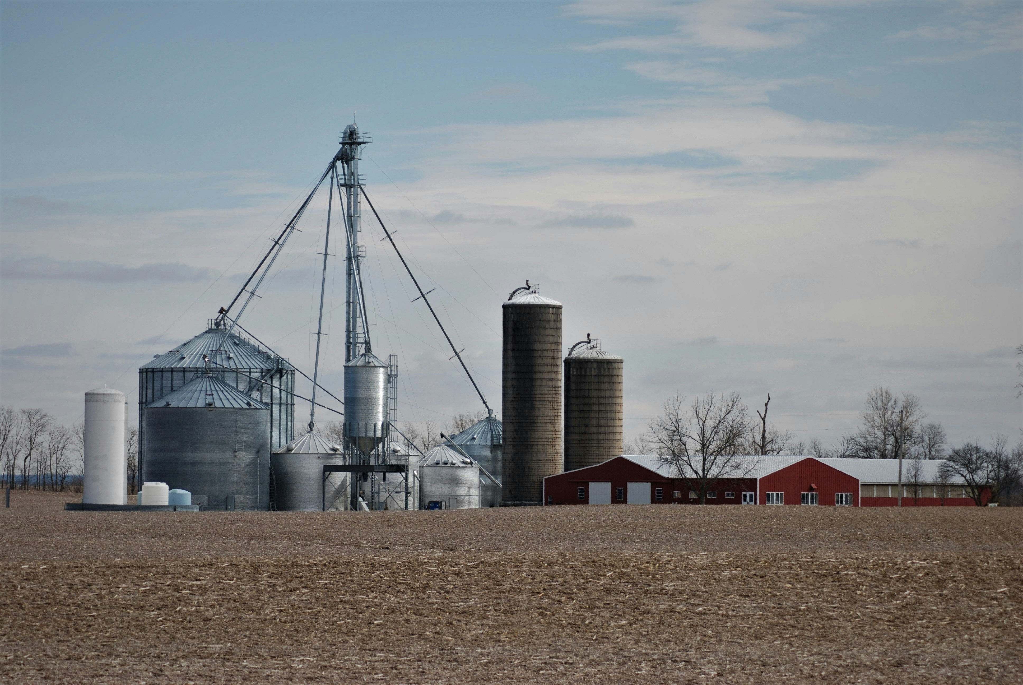 A farm with silos and silos in the distance photo – Free Grey Image on ...