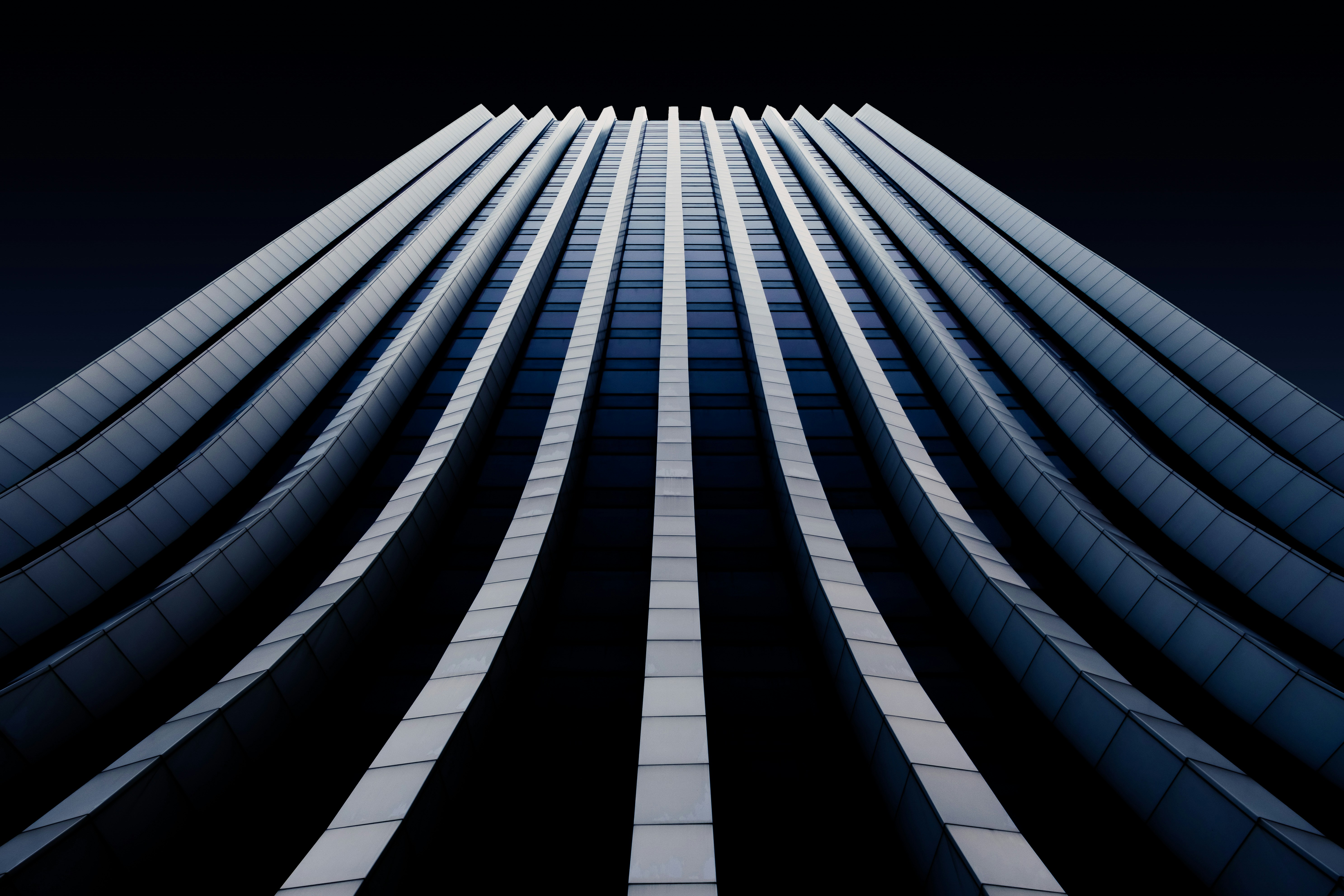 Abstract architecture with curved lines of a modern building against a dark sky.