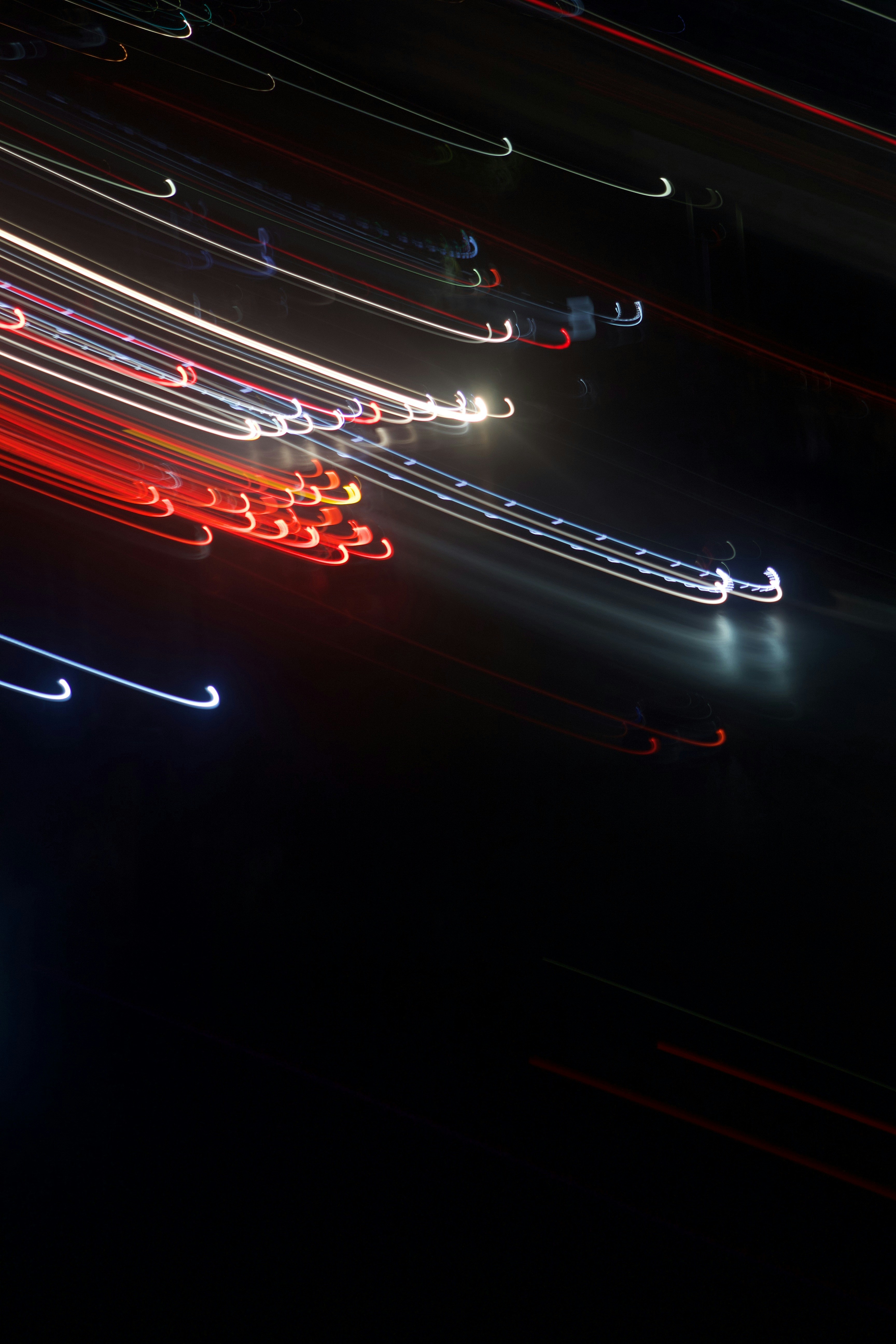 Dynamic light trails weave through a dark urban landscape, creating an abstract representation of movement and energy.