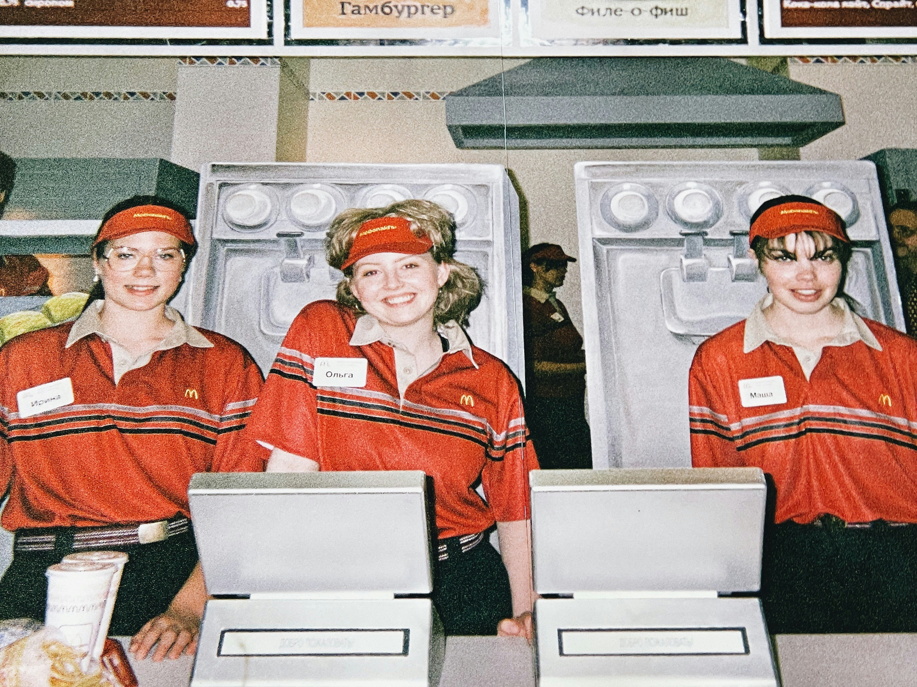 a group of women standing next to each other in front of a refrigerator