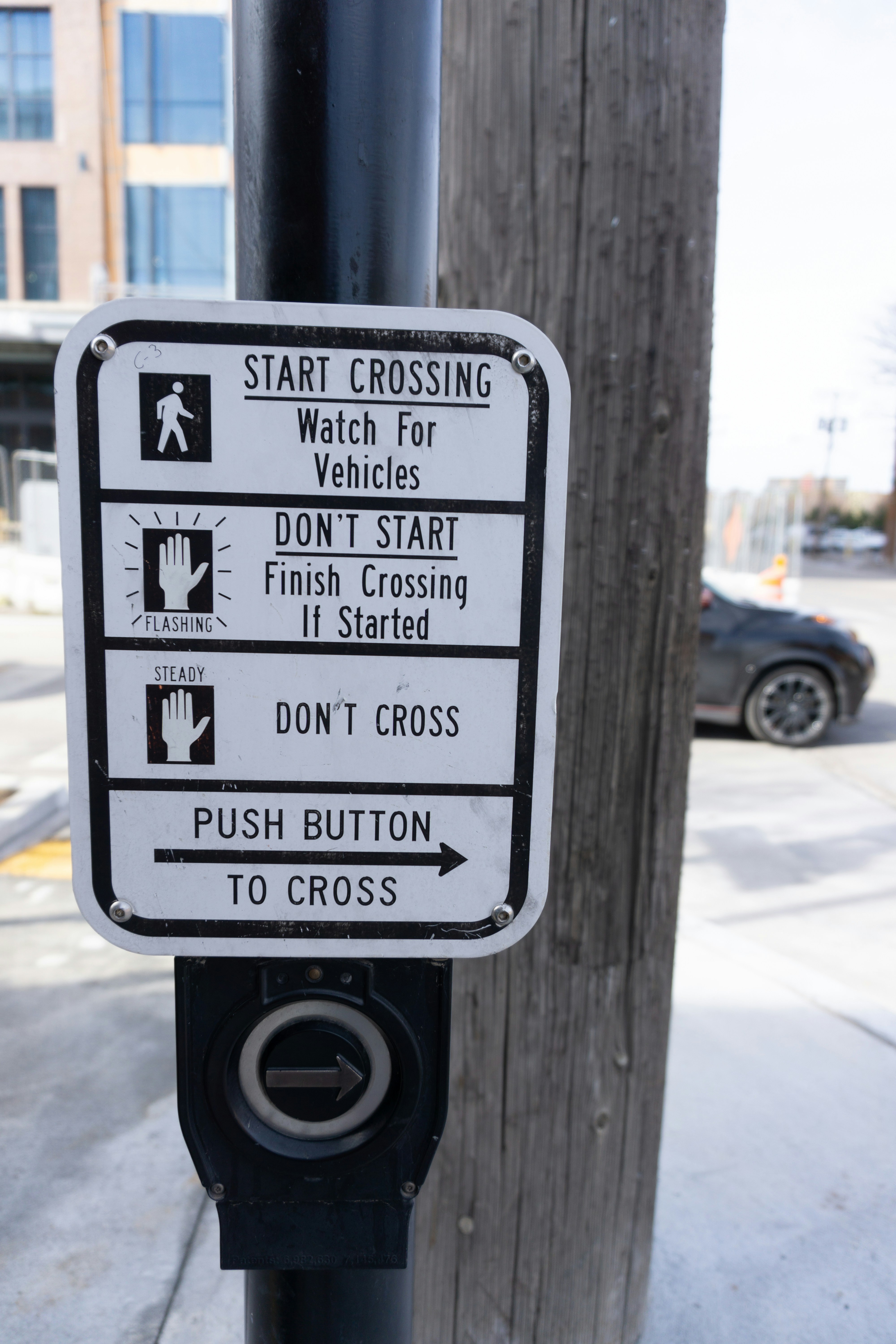 A street sign on a pole on a sidewalk photo – Free Grey Image on Unsplash