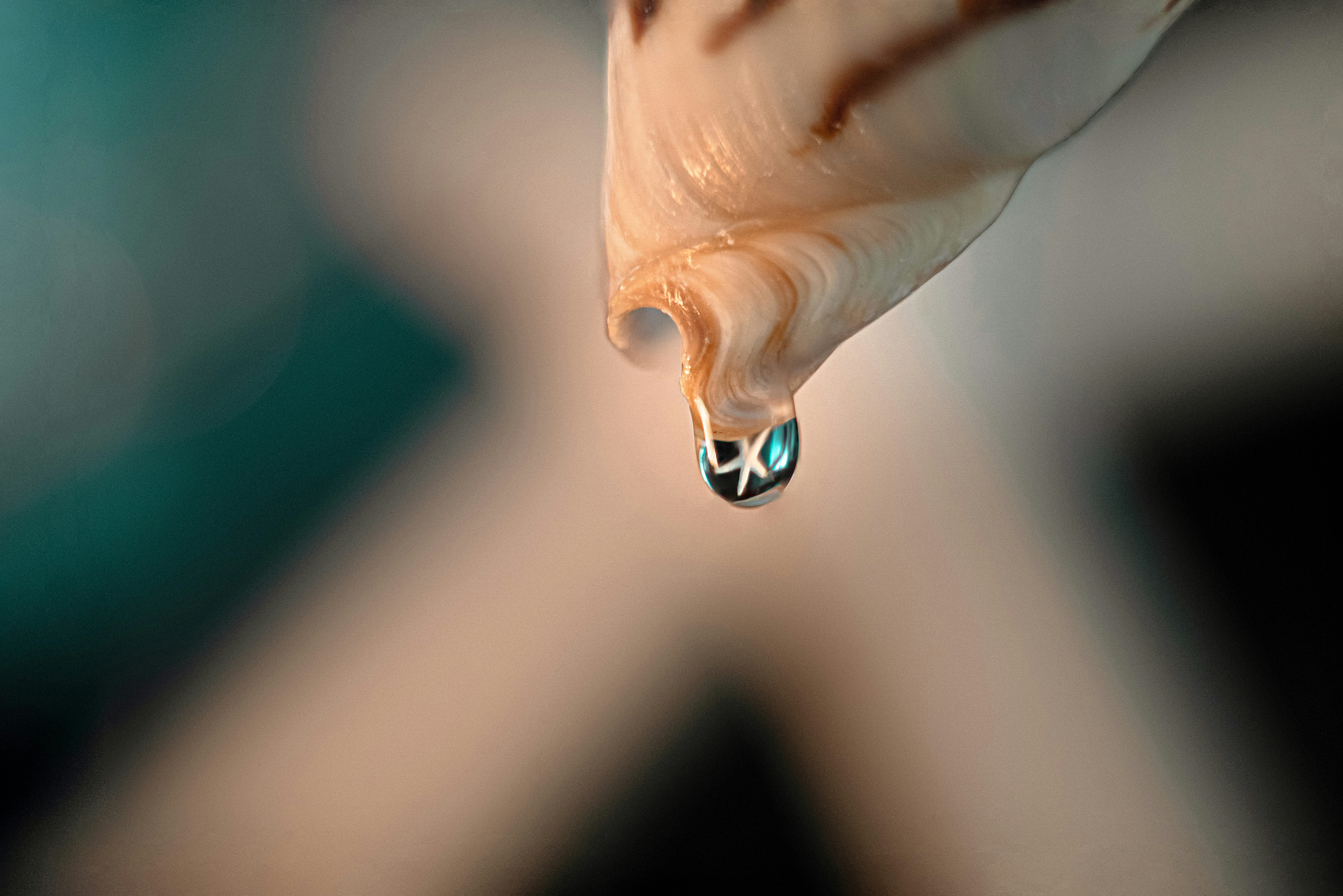 a drop of water that is hanging from a pipe