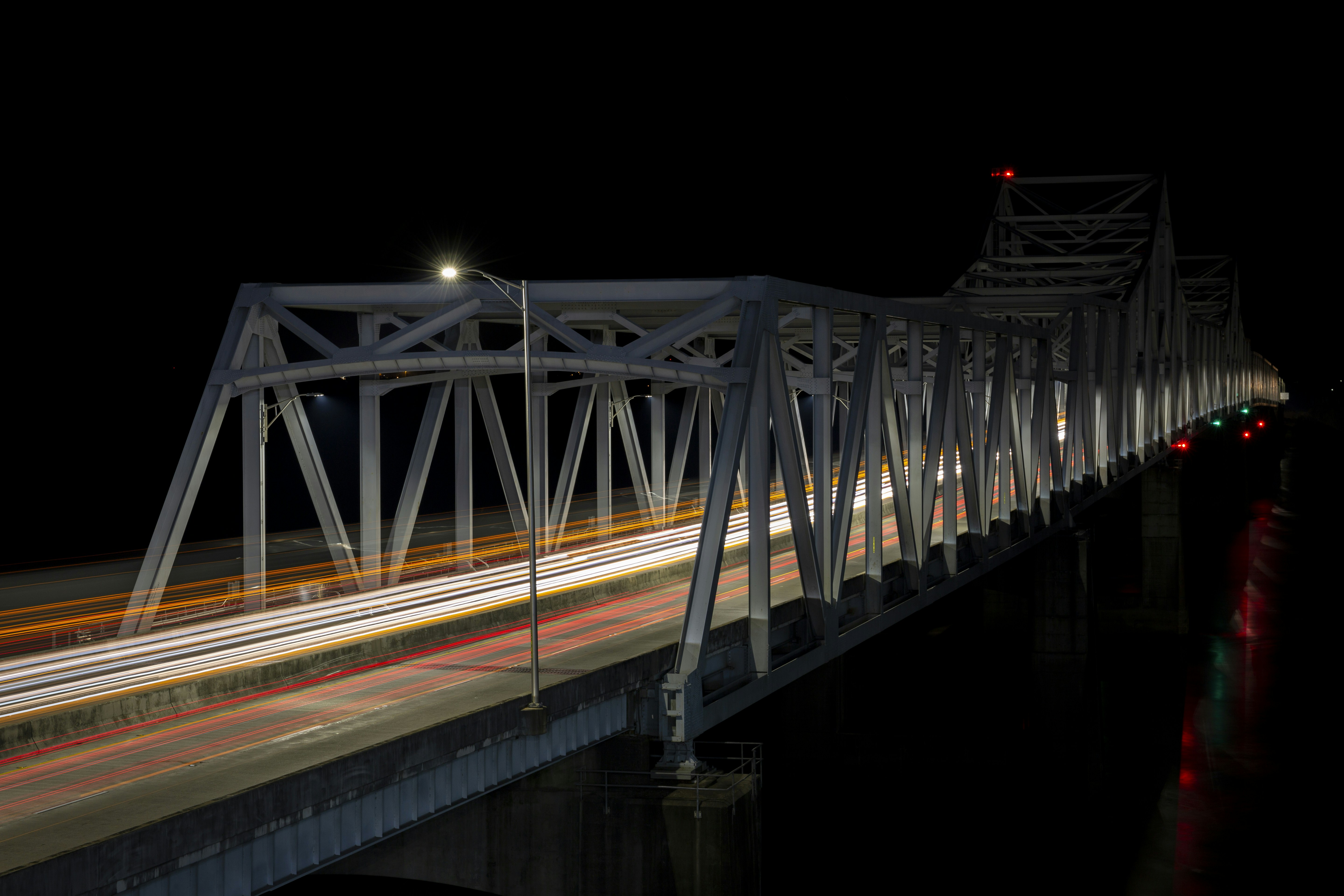Steel Serpent: Nighttime Truss Bridge in Motion