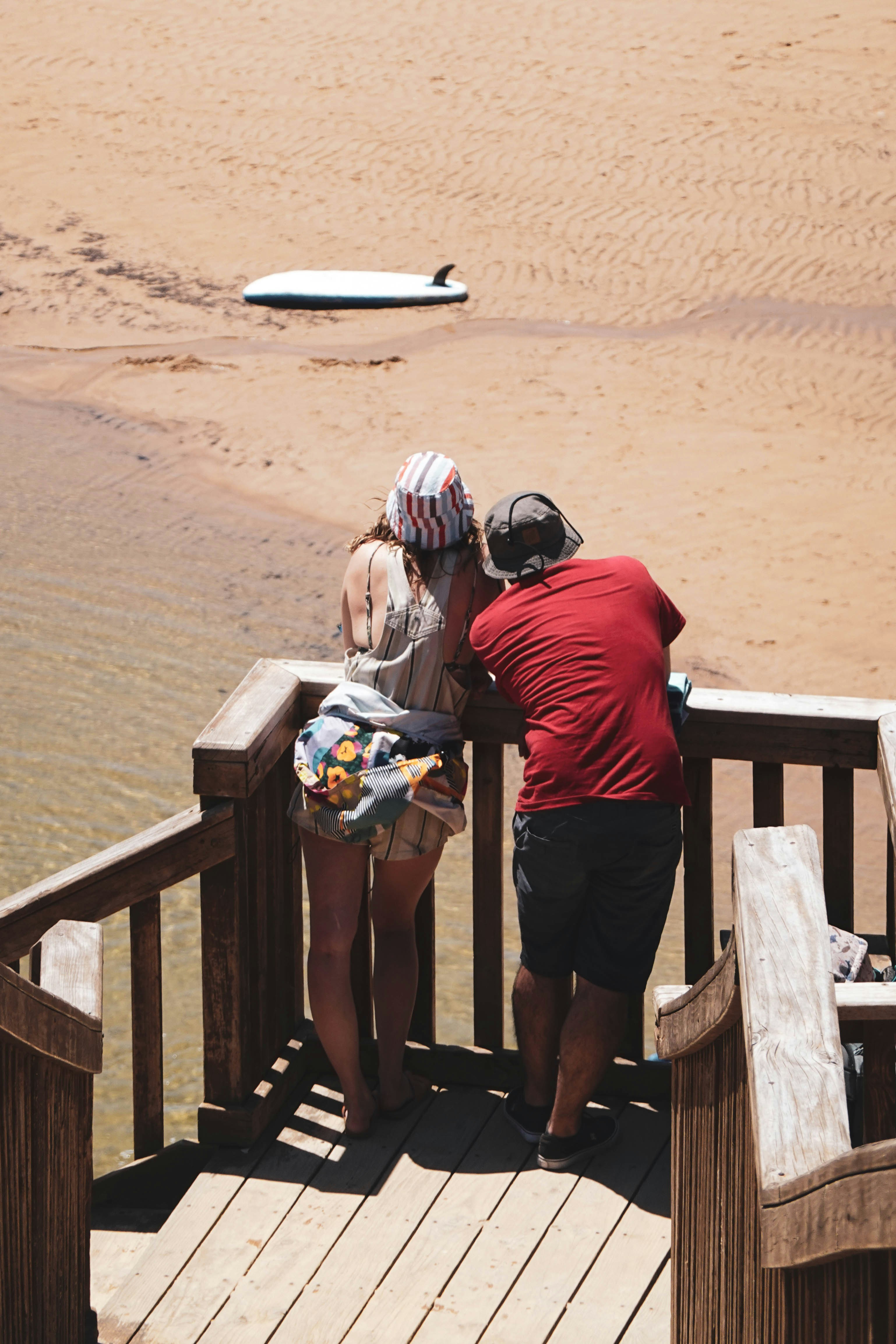 Dockside Gaze: Red Shirt and Striped Hat Overlooking the Shore