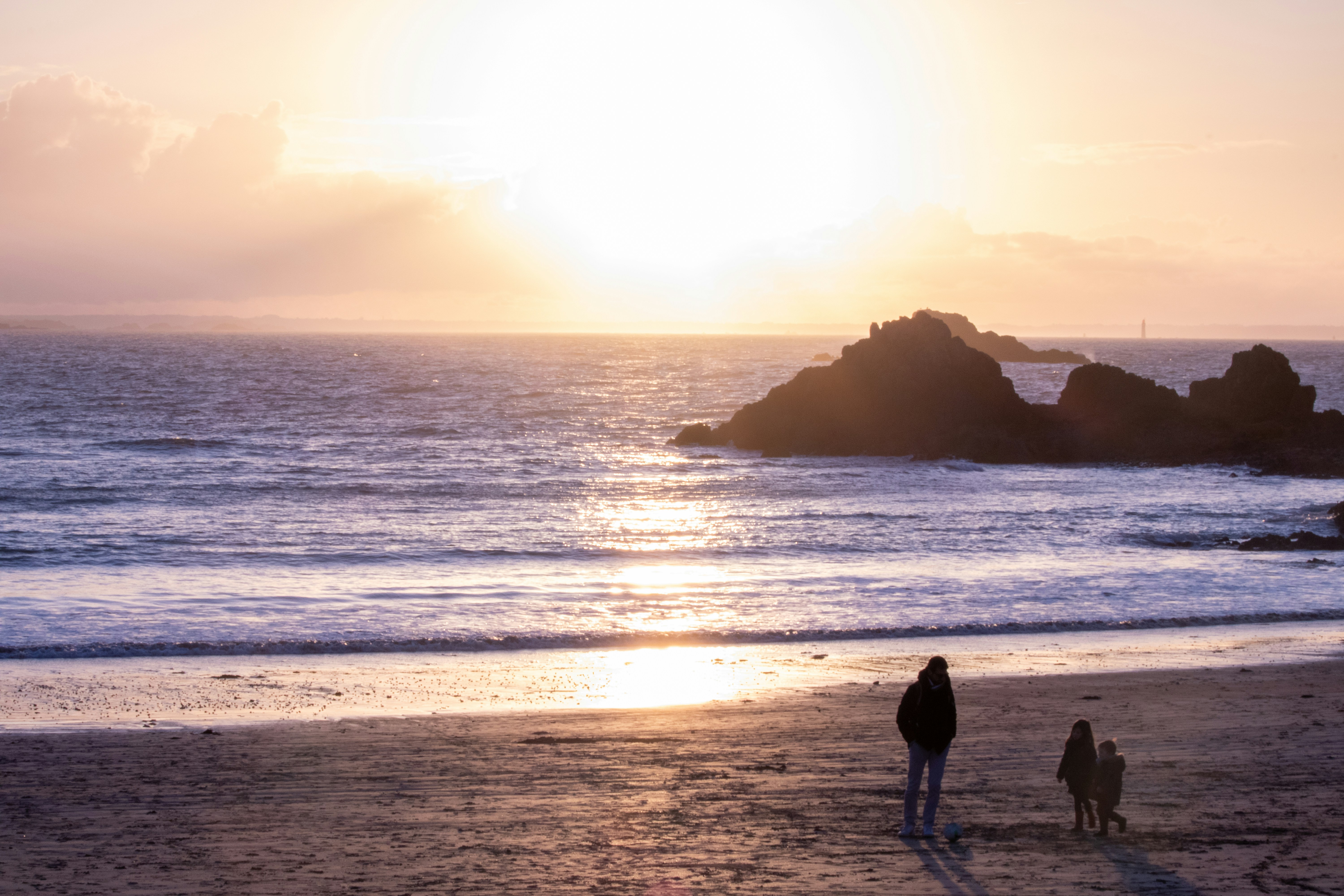 Foto Un par de personas de pie en la cima de una playa de arena ...