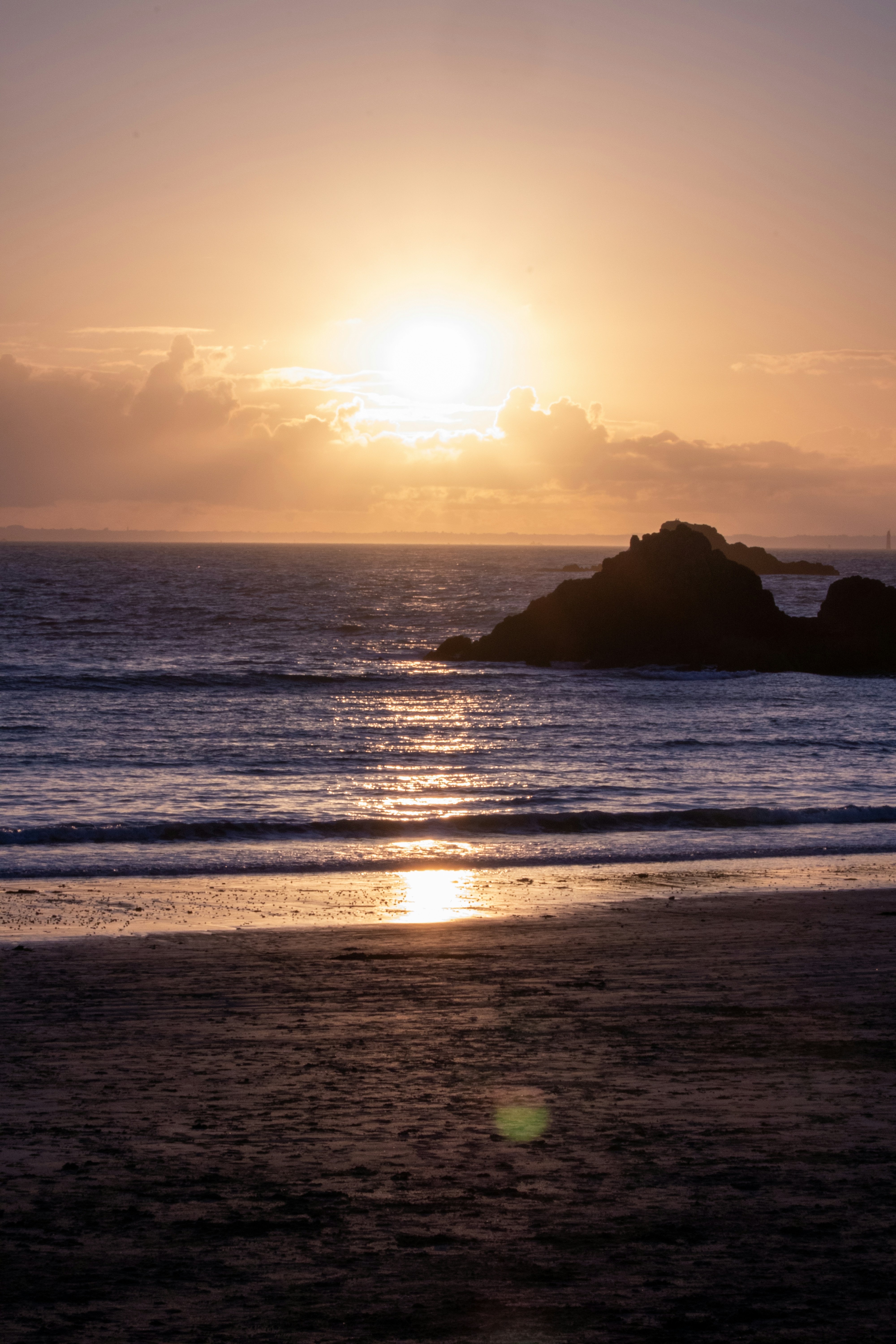 Foto El sol se está poniendo sobre el océano en la playa – Imagen Santo ...