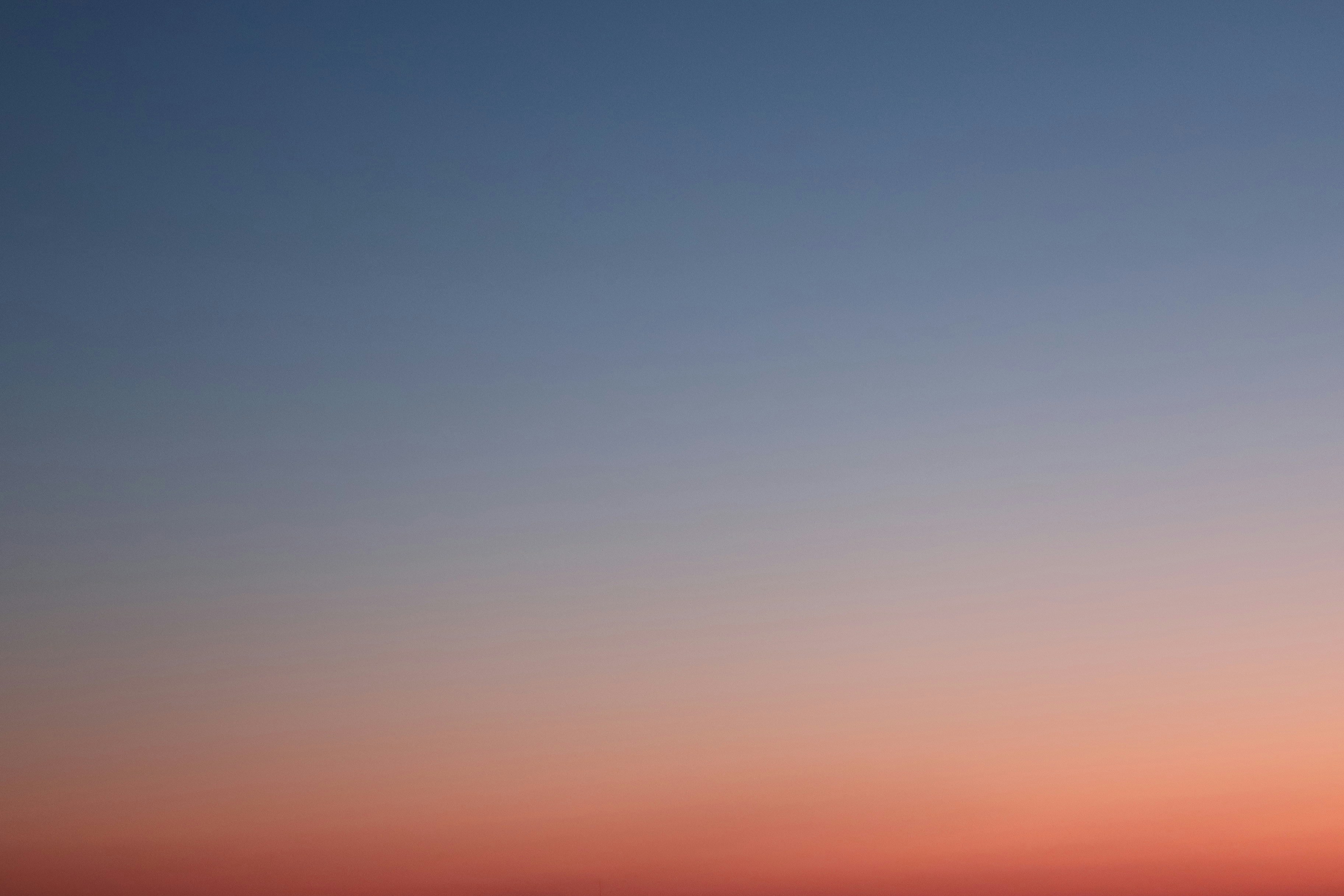 a plane flying in the sky at sunset