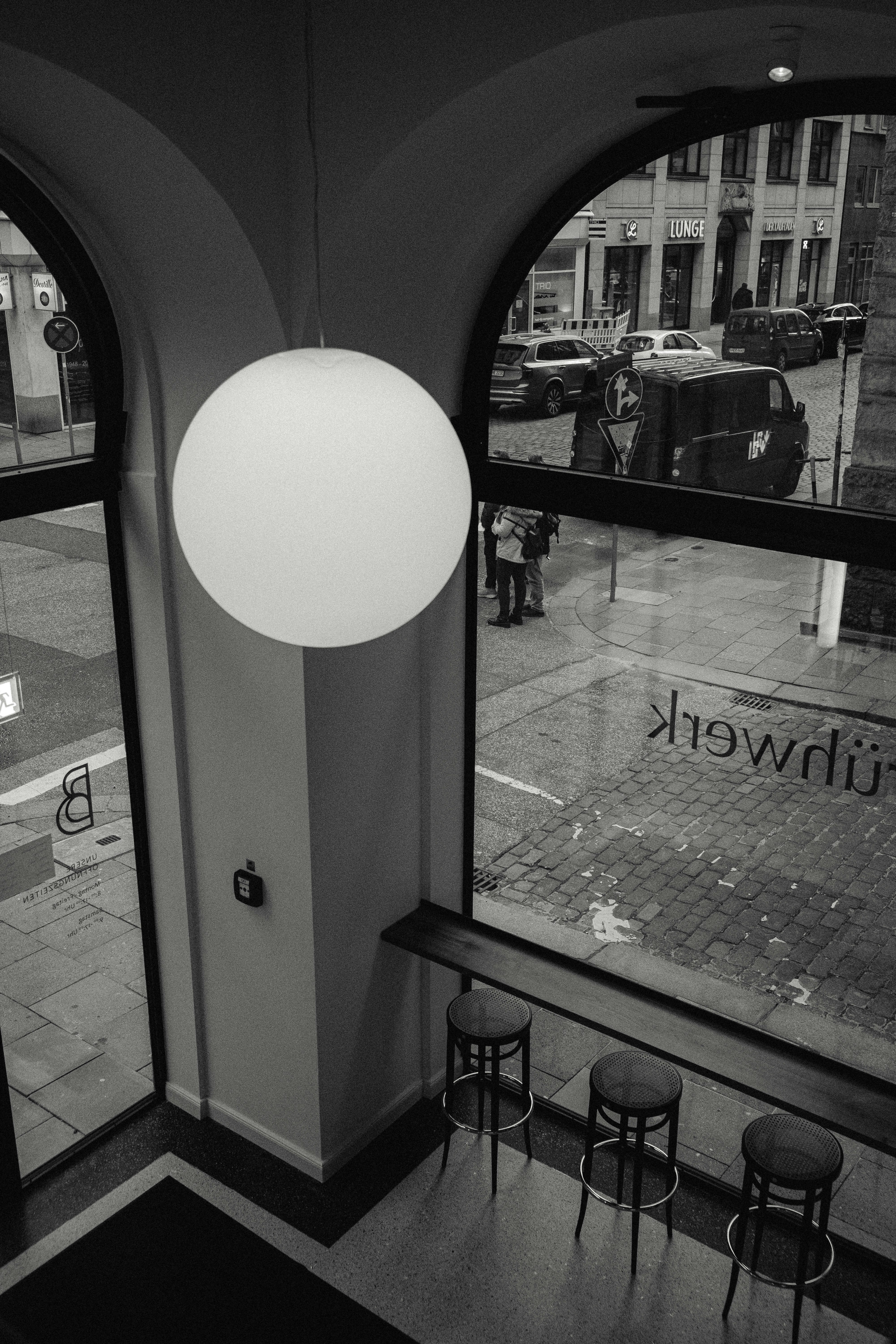 a black and white photo of a window with a view of a street