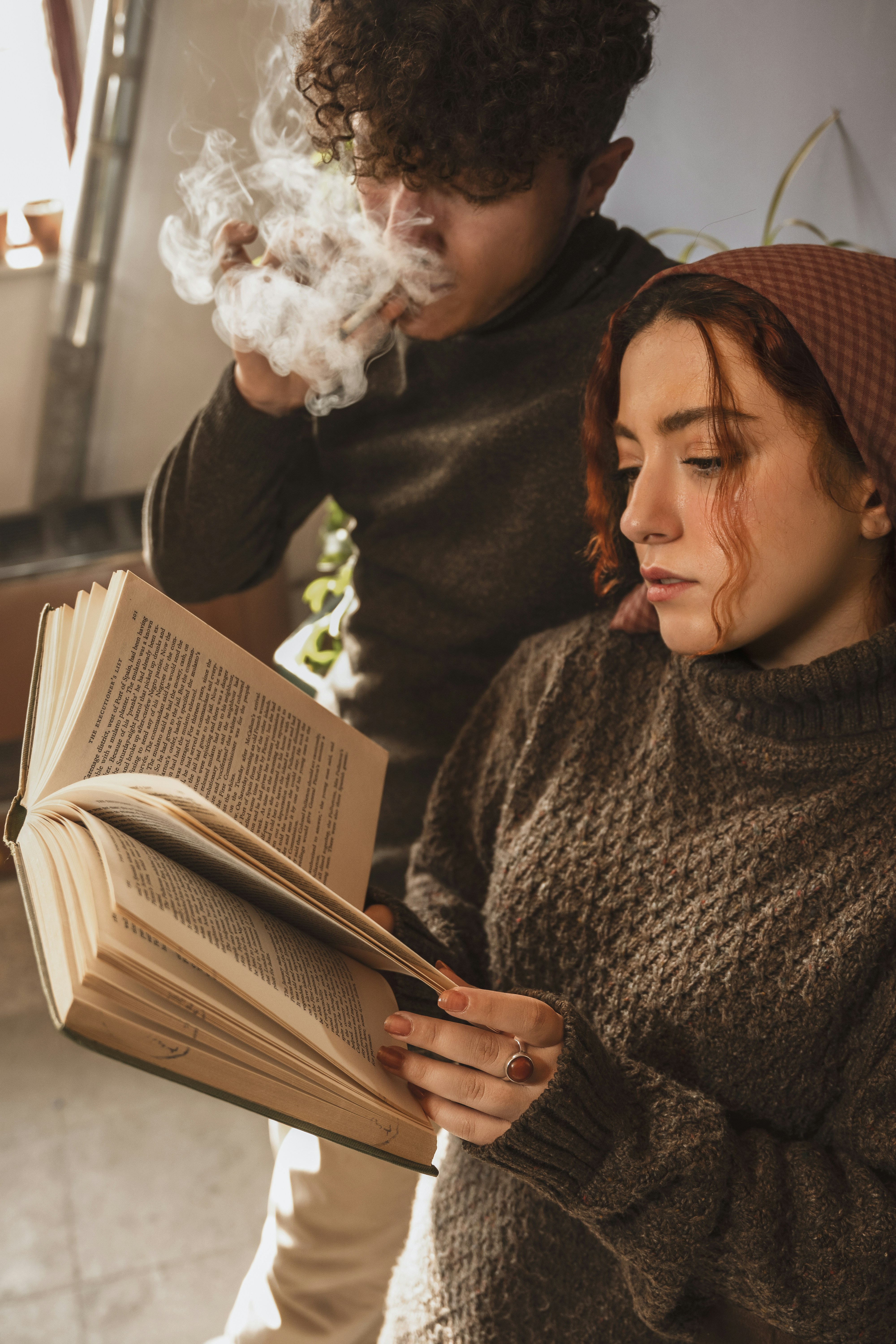 A man and a woman sitting down reading a book photo – Free Human Image ...