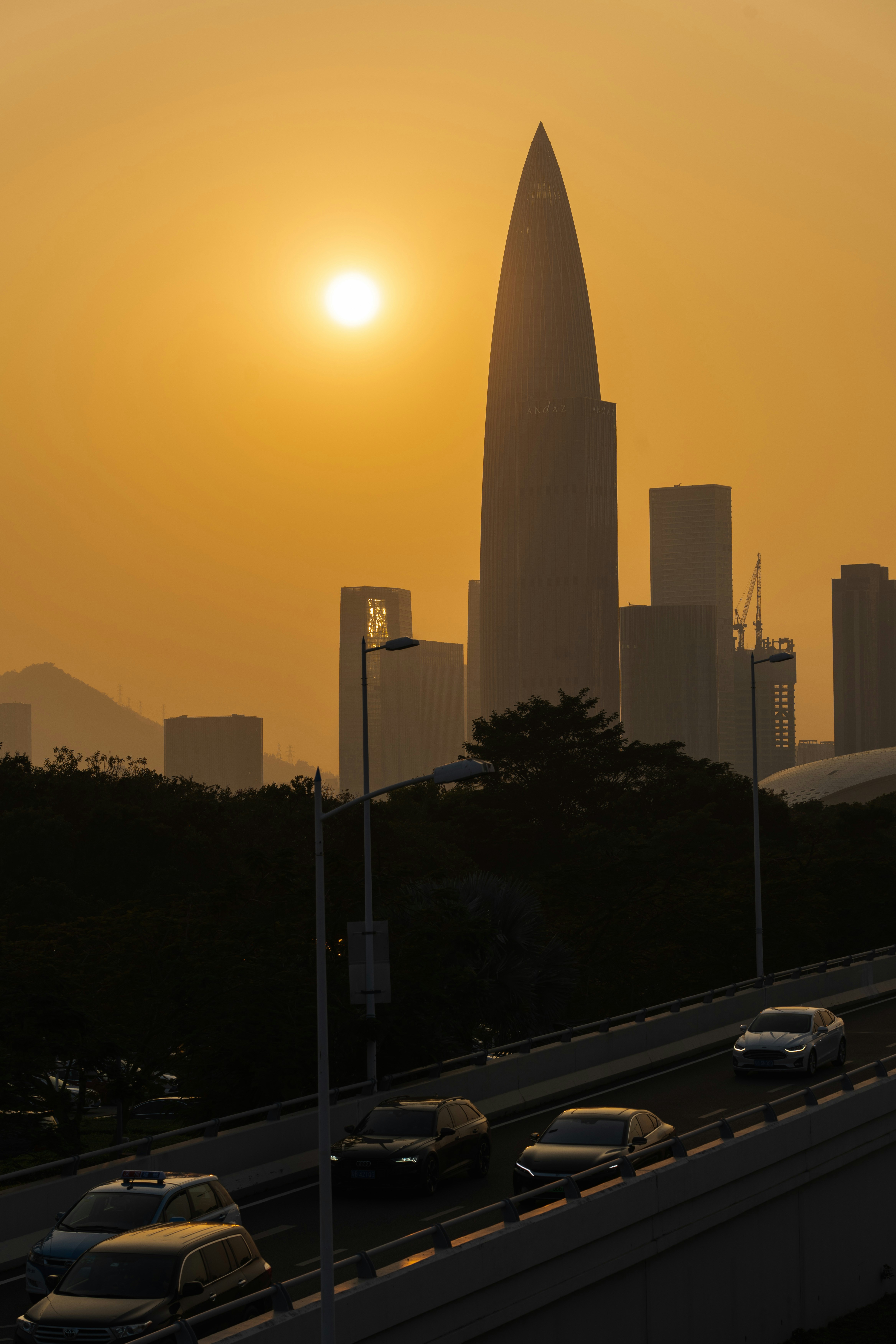 The sun is setting over a city with tall buildings photo – Free Green ...
