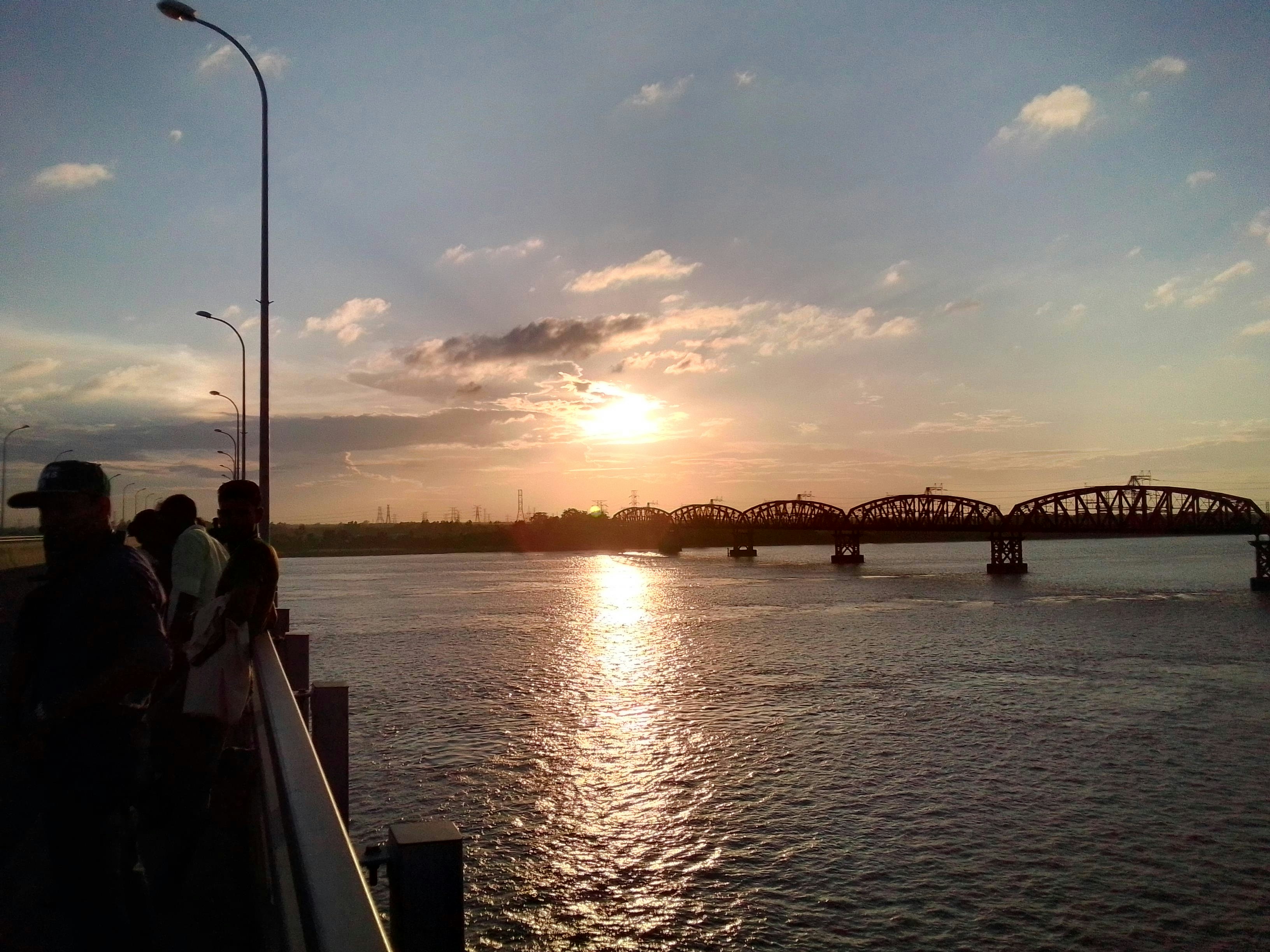 a group of people standing on the side of a bridge