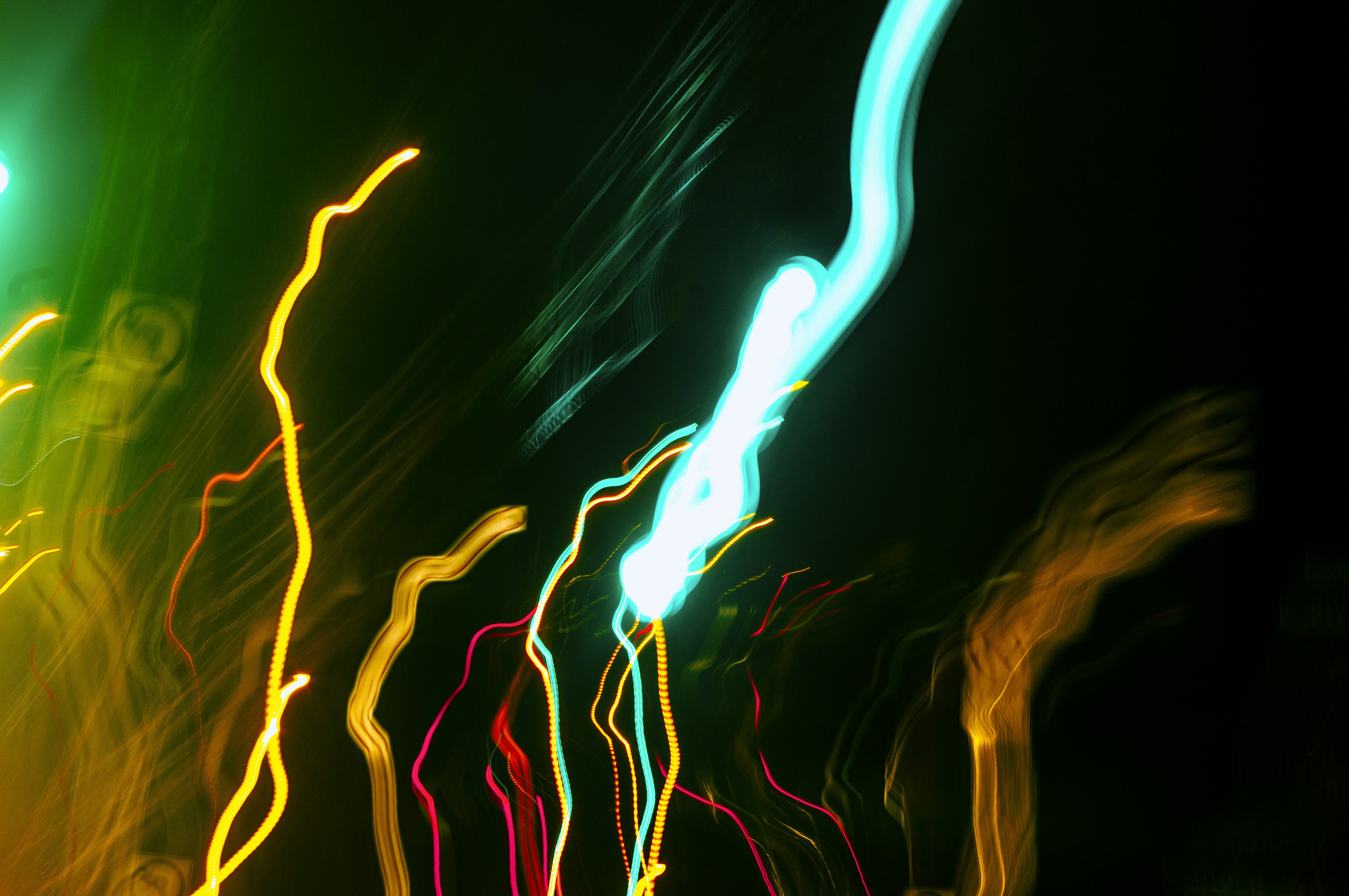 Abstract light trails create a vibrant tapestry of colors against a dark backdrop, evoking energy and movement.