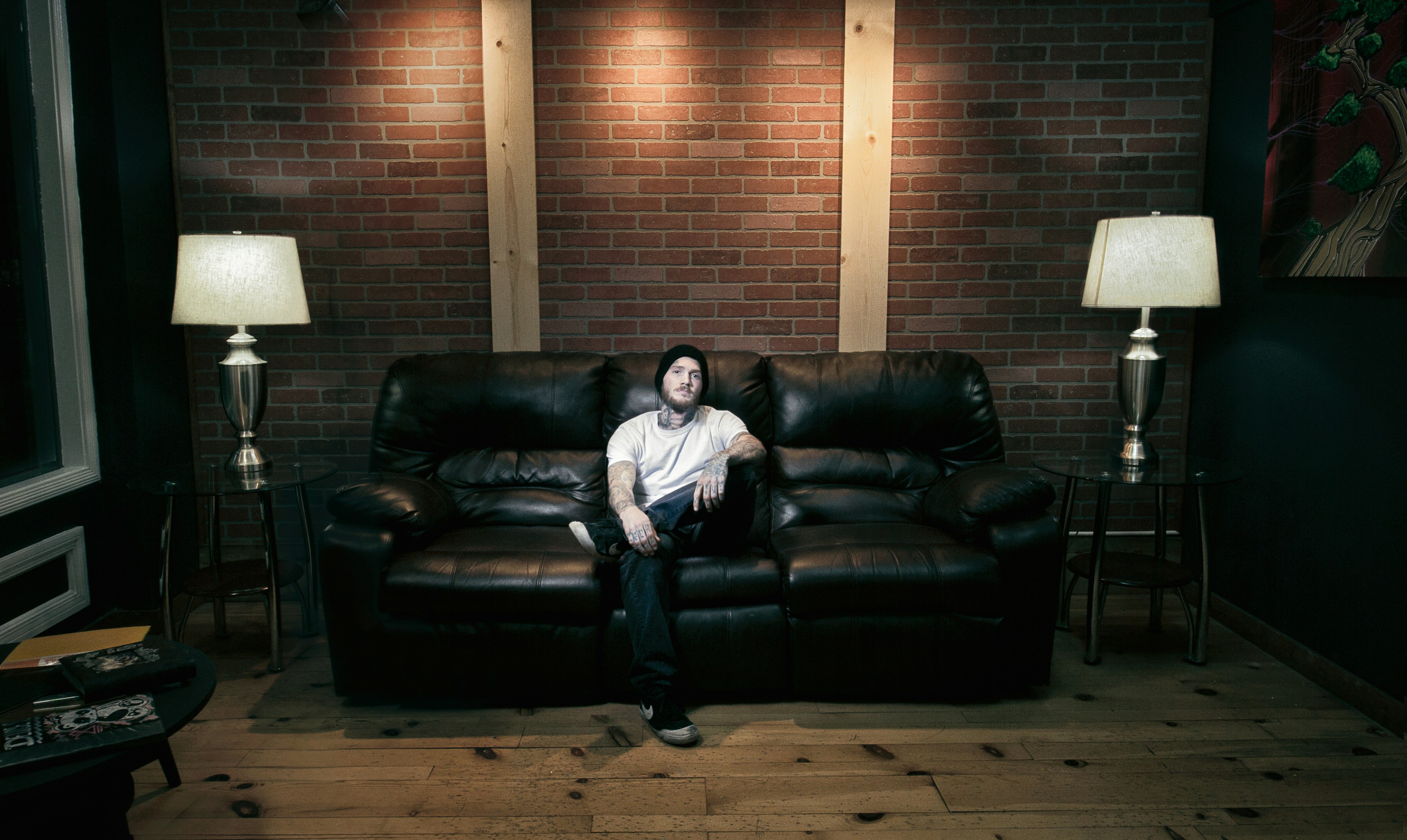 A man sitting on a couch in a living room photo – Free Portrait ...