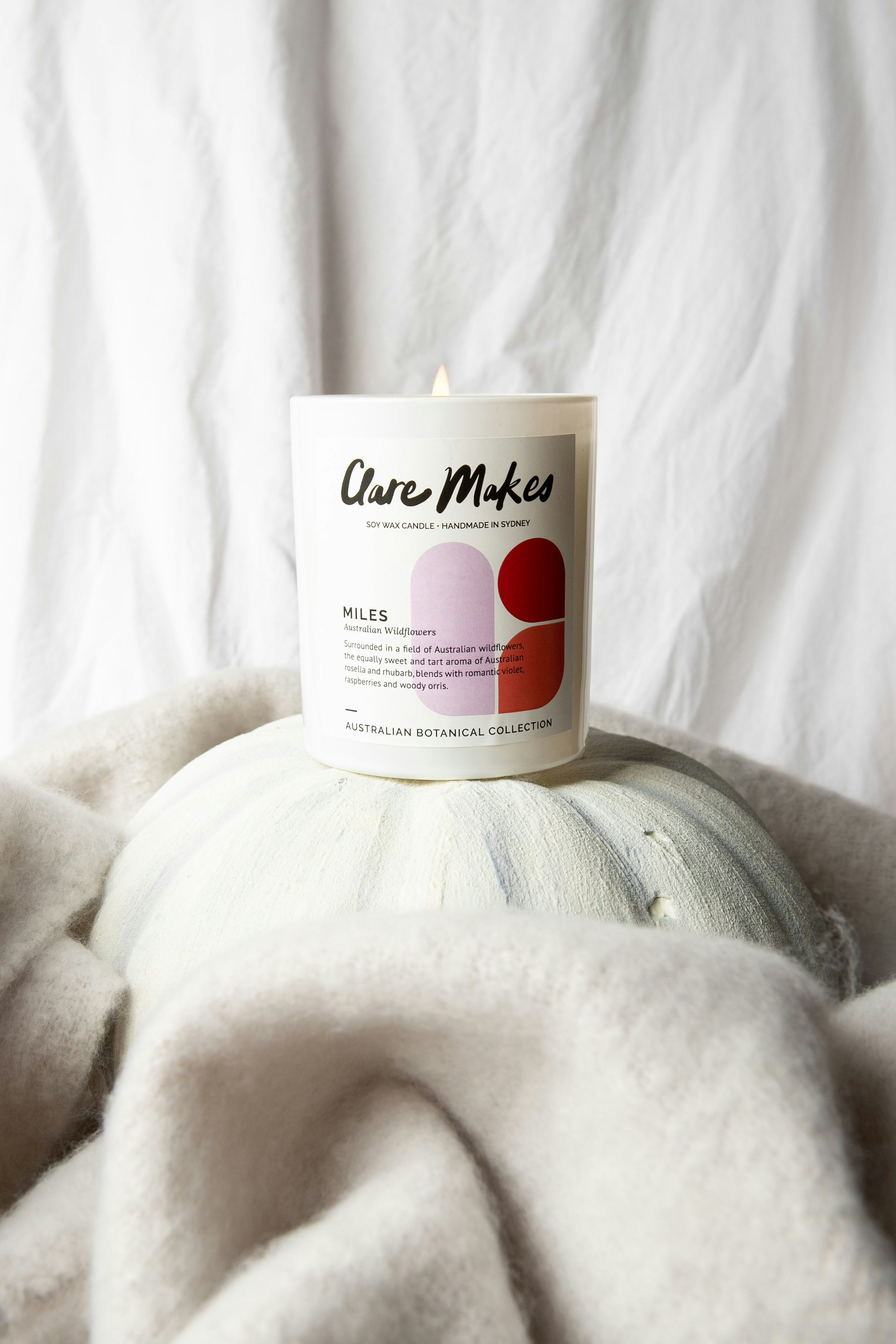a candle sitting on top of a white blanket