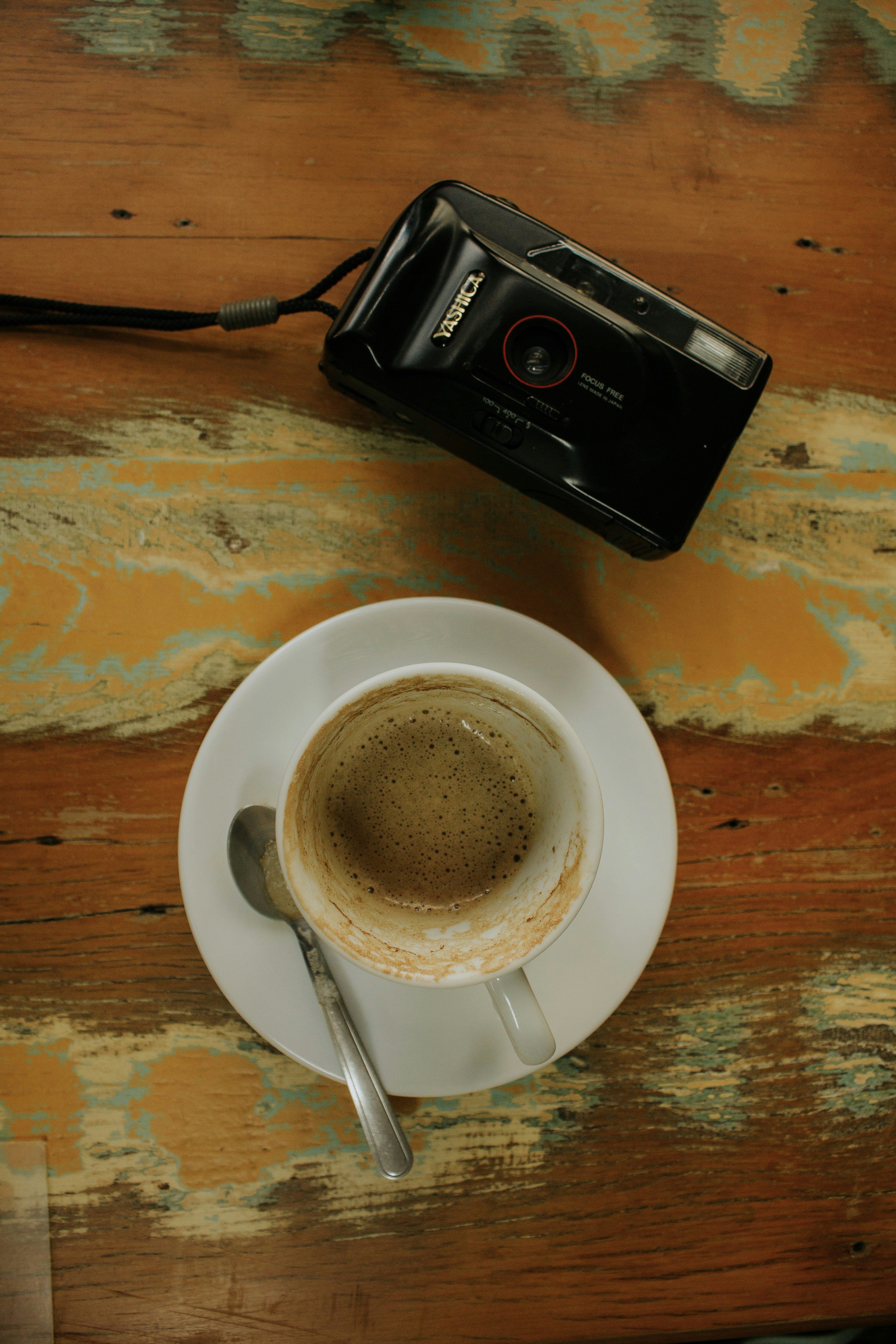 a cup of coffee and a camera on a table