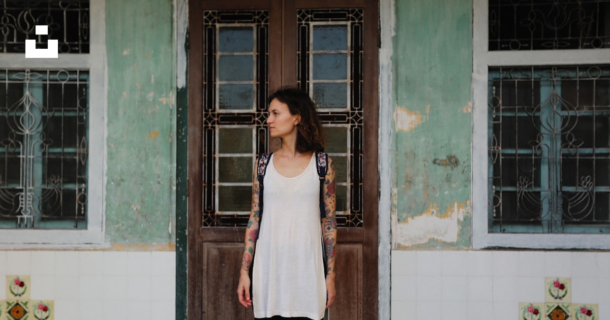 Foto Una Mujer Parada Frente A Una Puerta Imagen Gris Gratis En Unsplash