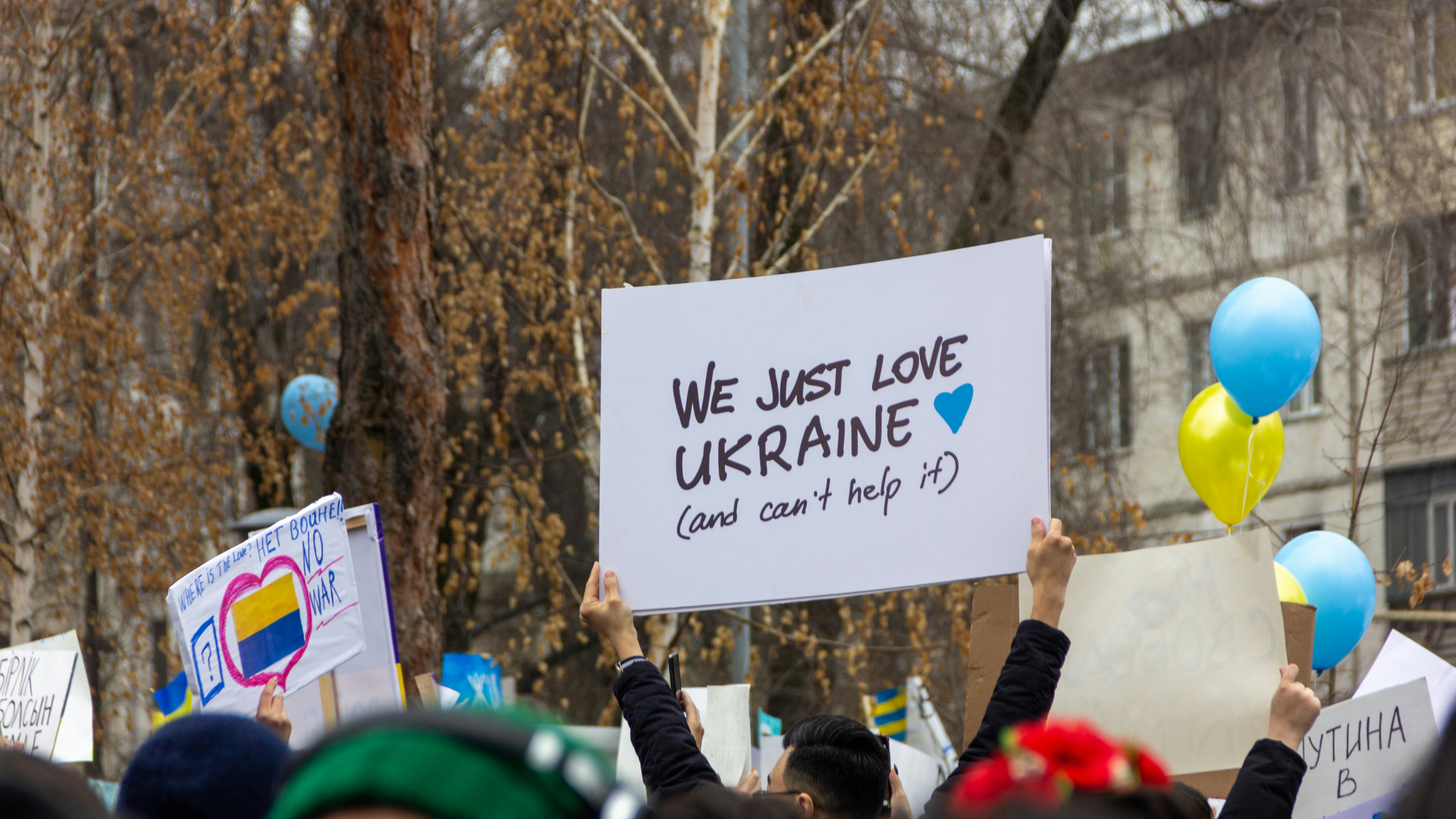 A group of people holding up signs and balloons photo – Free Almaty ...