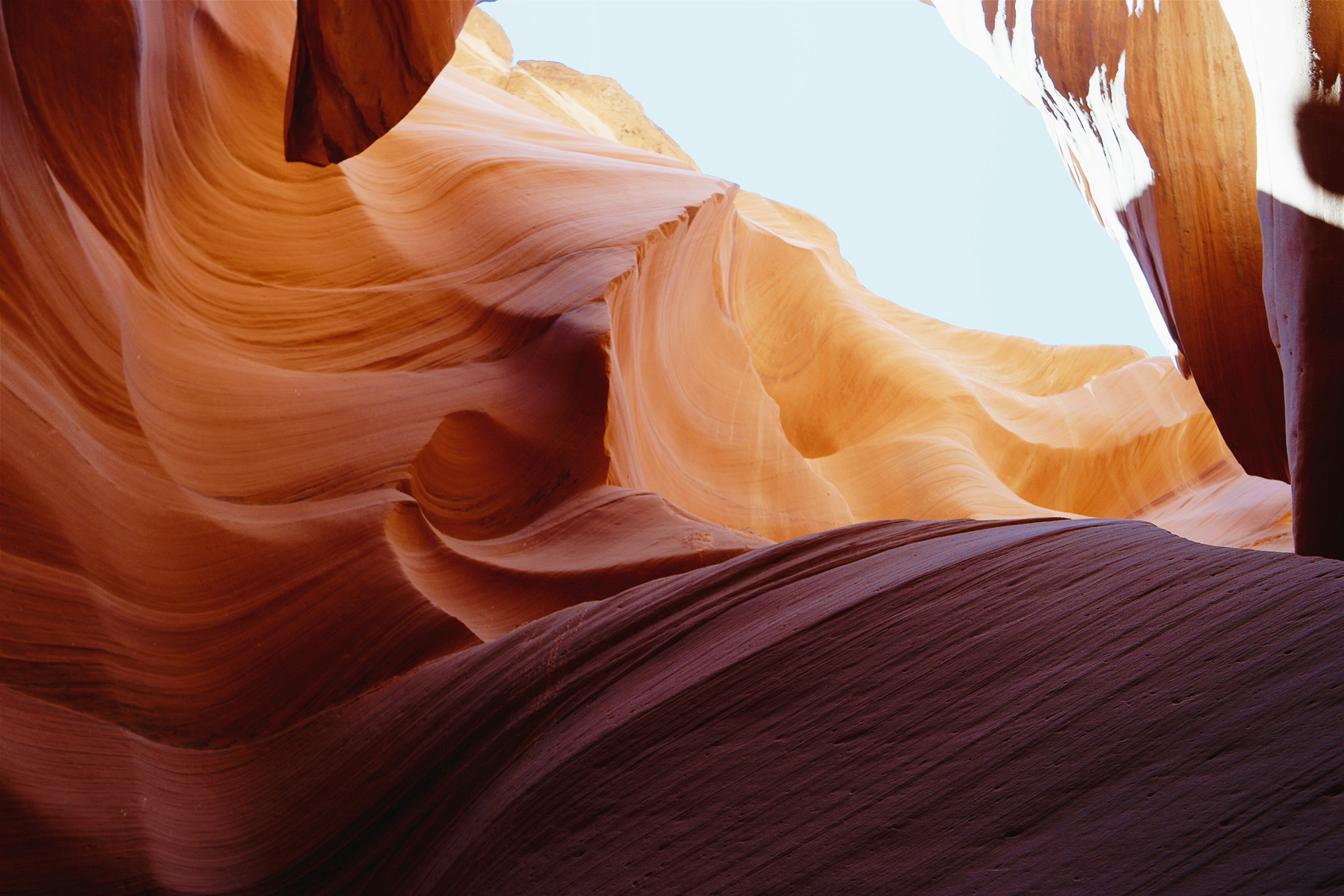 Undulating sandstone walls of a canyon illuminated by soft light filtering from above.
