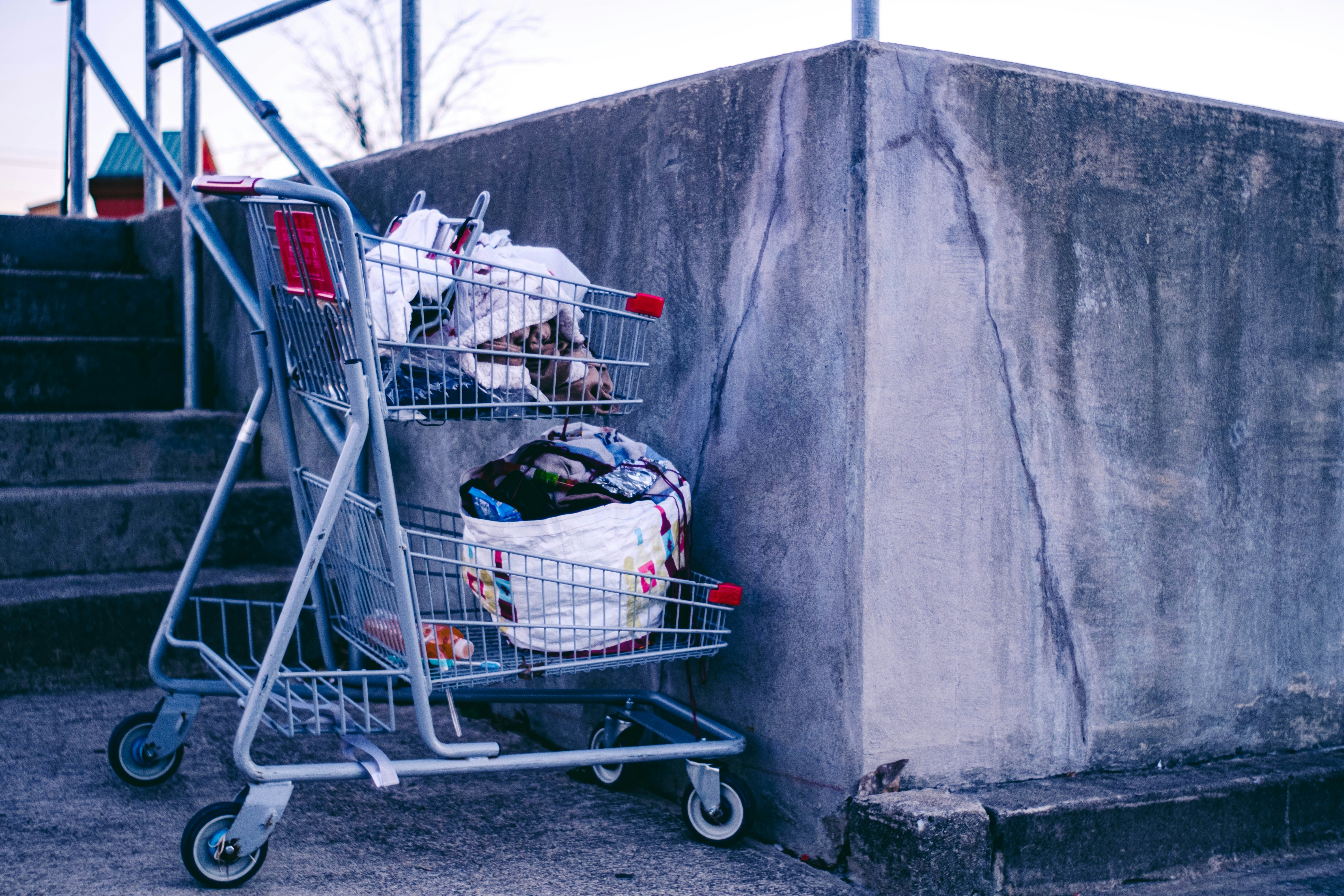 Un chariot assis à côté d’un mur de ciment photo – Image gratuite de ...