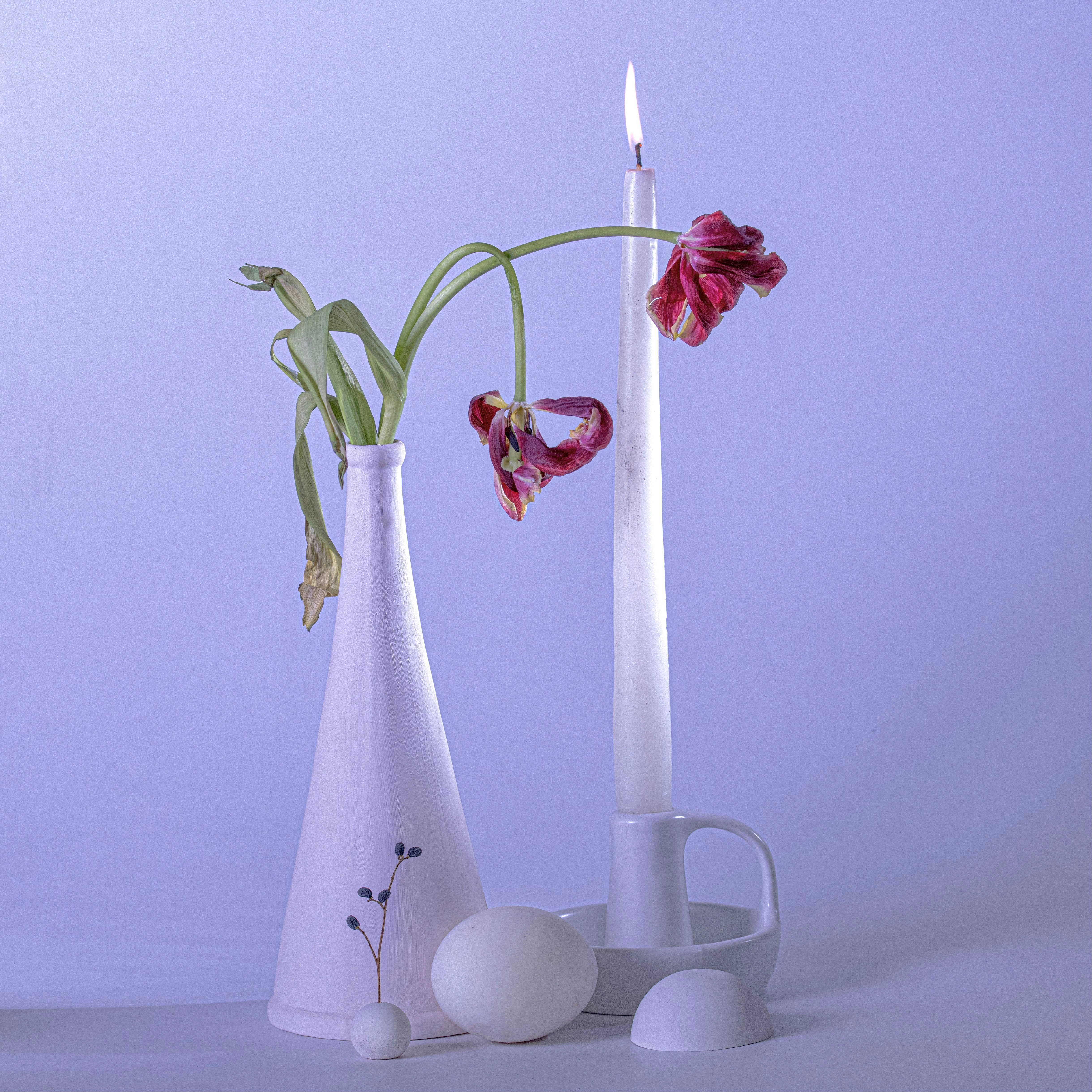 a couple of white vases with flowers in them