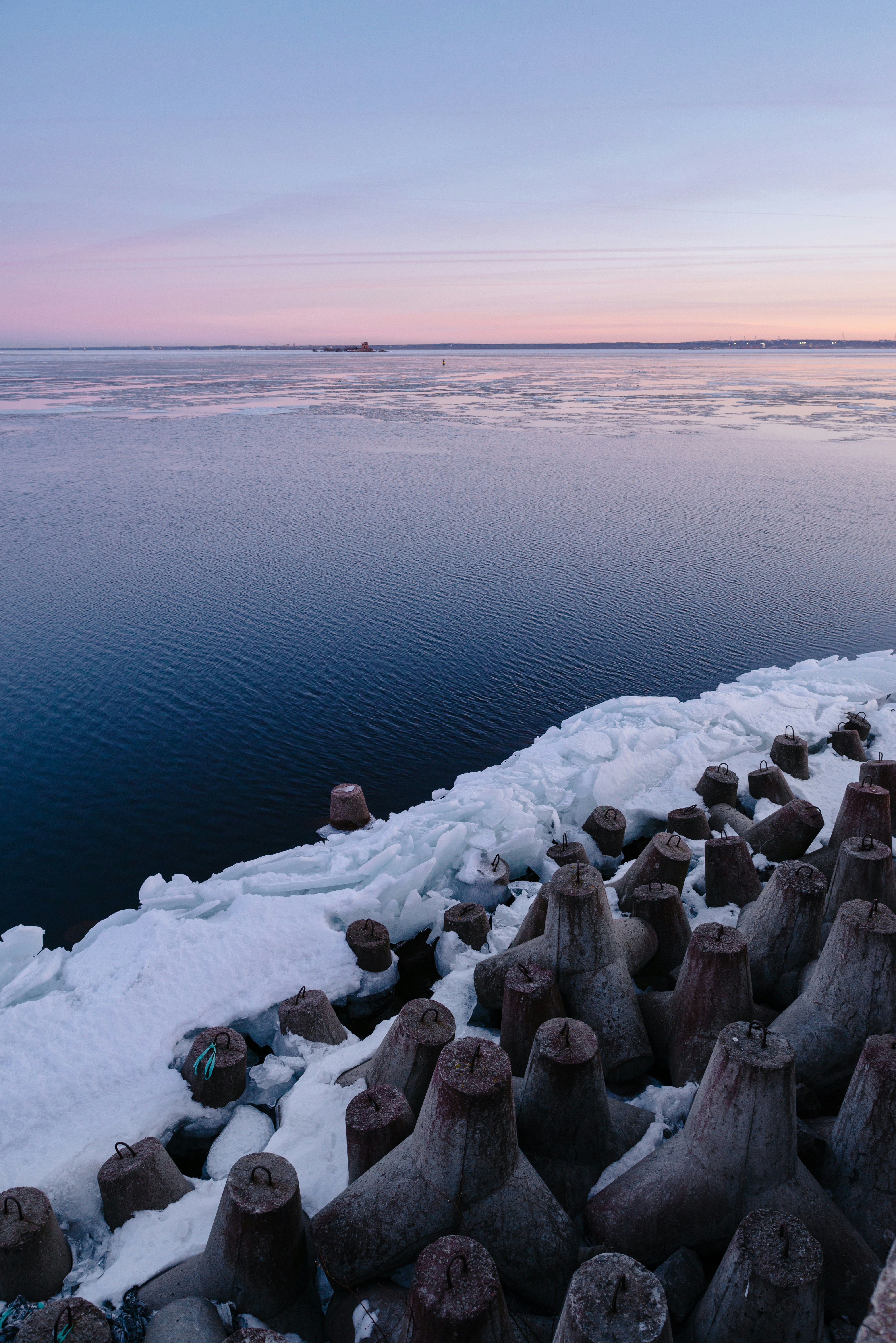 Ice-Edge Tetrapods: Concrete Armor Framing a Dusk-Hushed Sea