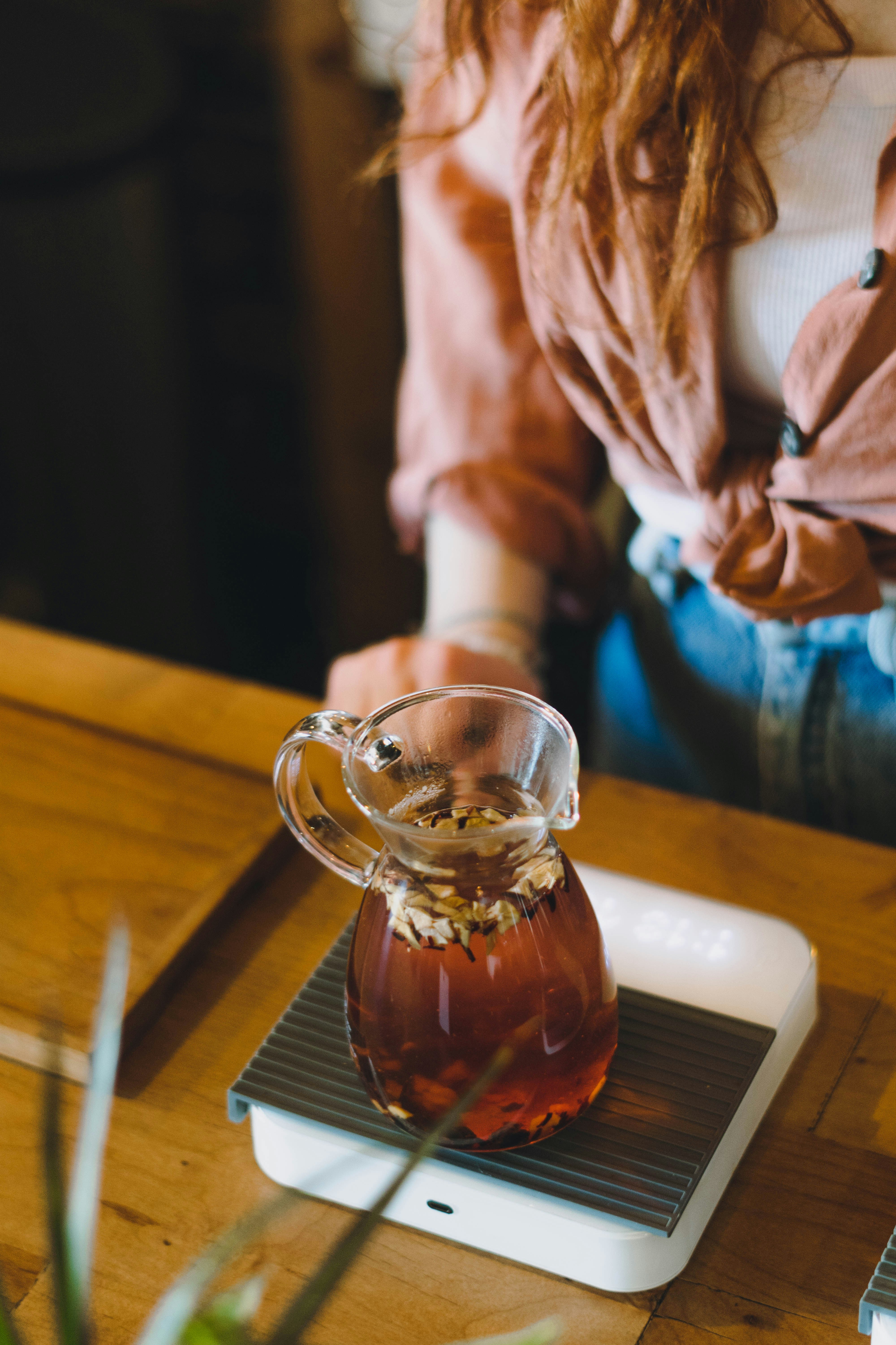 A woman sitting at a table with a pitcher of tea photo – Free Human ...