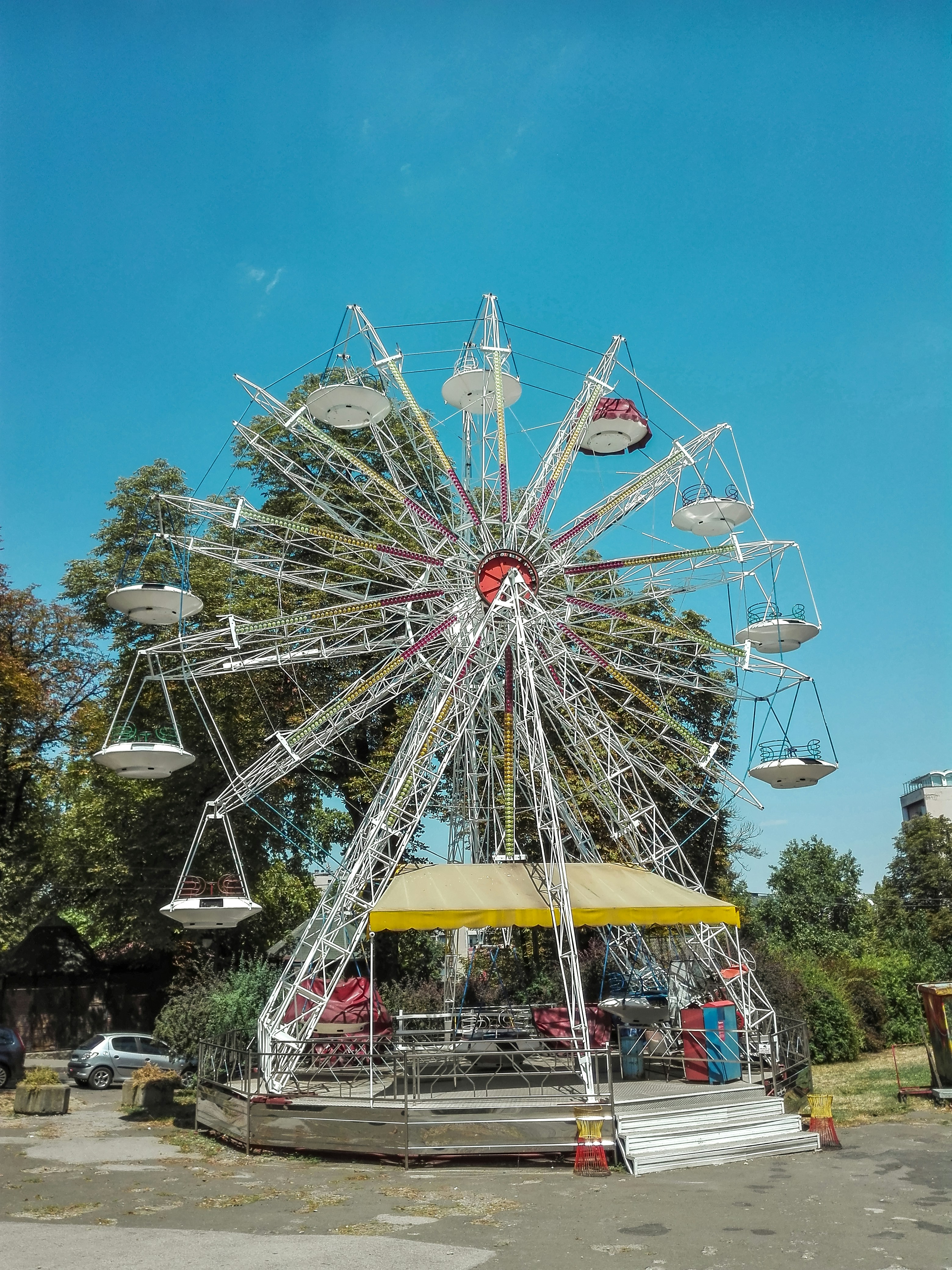 A vibrant Ferris wheel stands tall against a clear blue sky, showcasing its colorful gondolas and intricate structure.