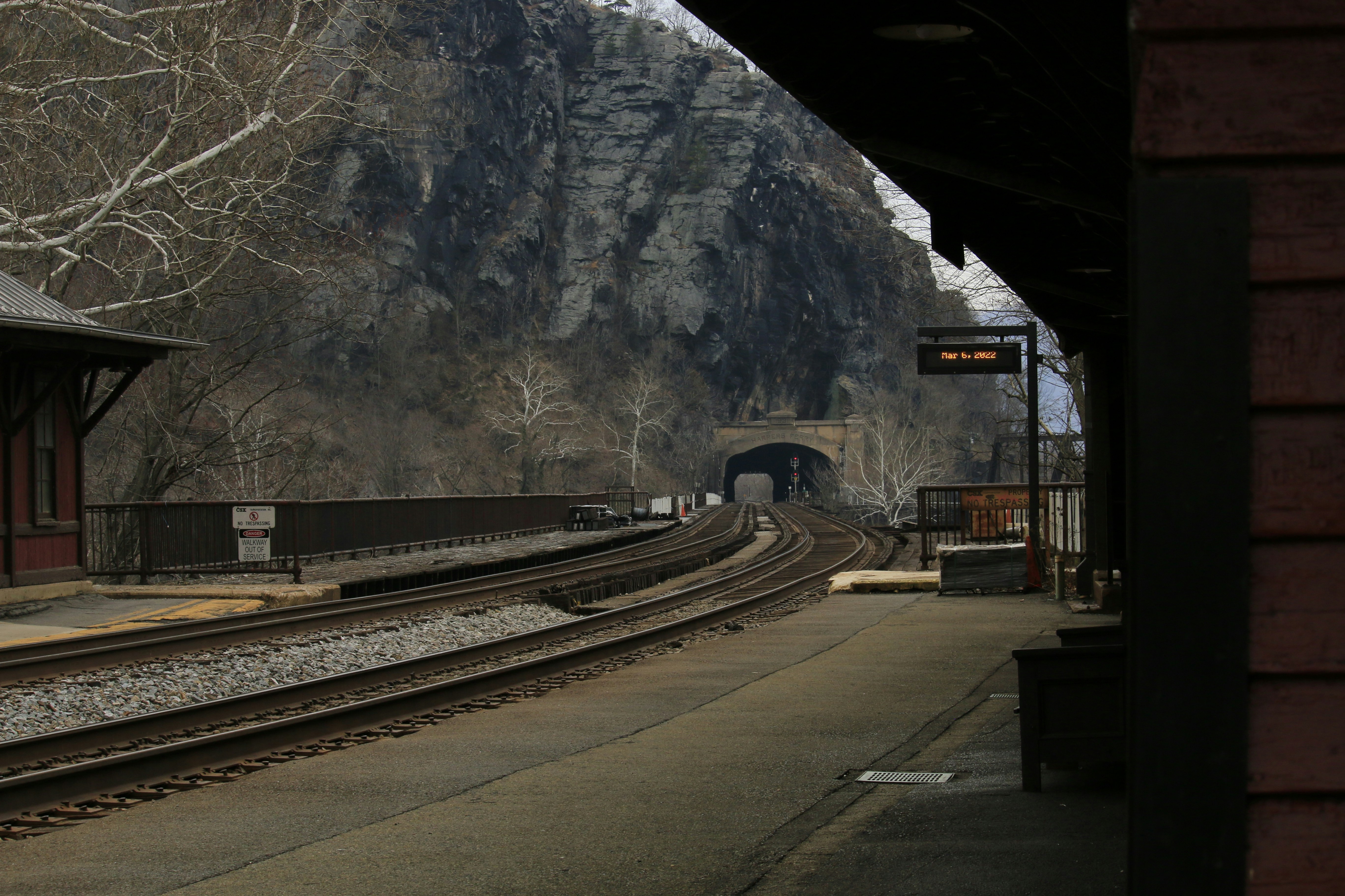 Converging Rails Toward a Shadowed Mountain Tunnel